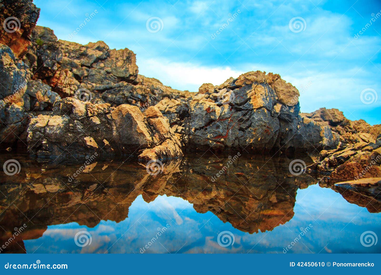 Rocks and Their Reflection in the Sea at Daytime Stock Photo - Image of ...