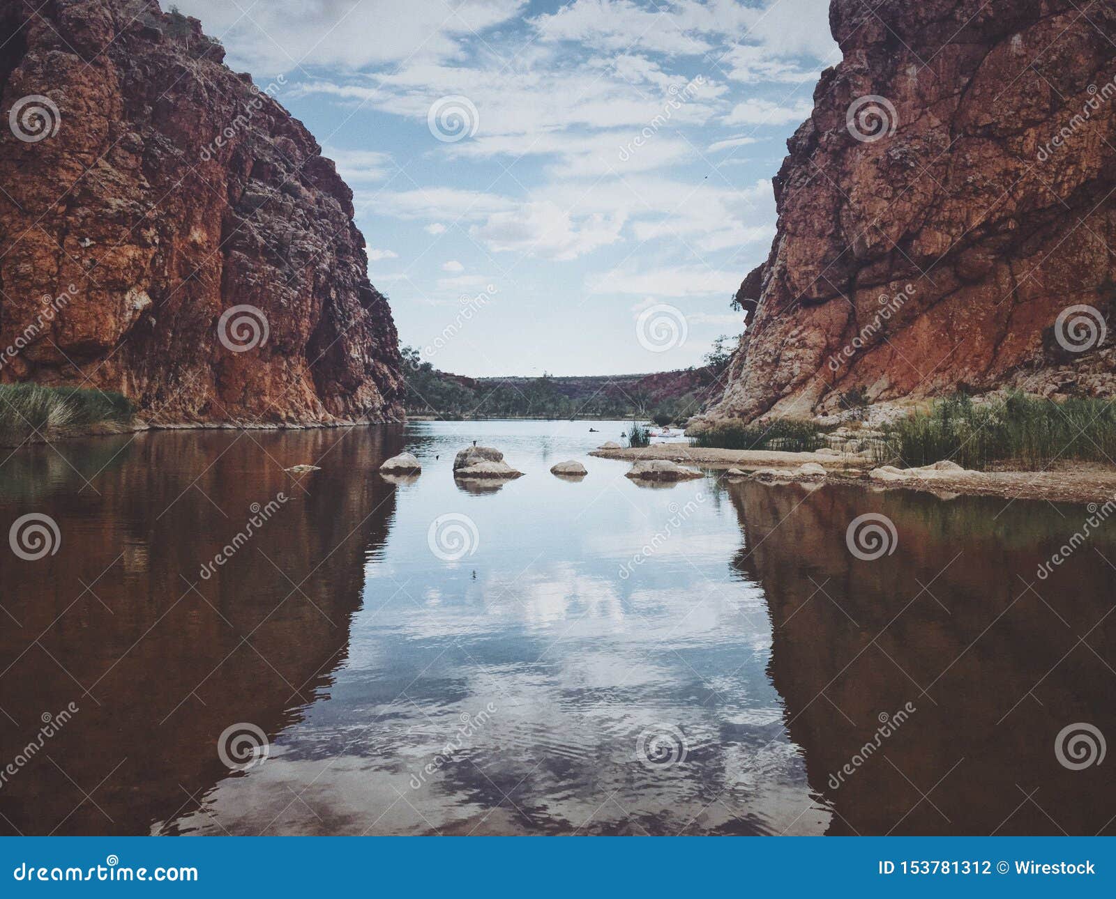 Rocks in the Water in the Middle of Cliffs and a Reflection of the Sky ...