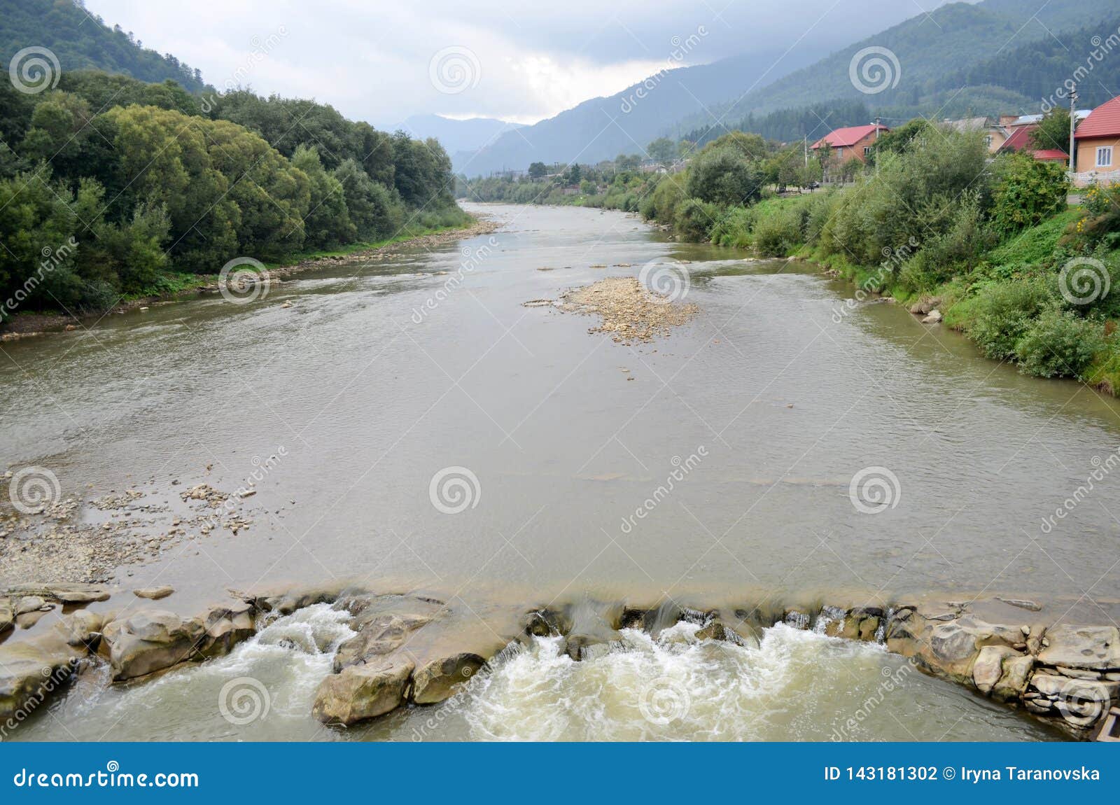 Rocky Mountain River on the Background of Mountains Houses and Sky ...