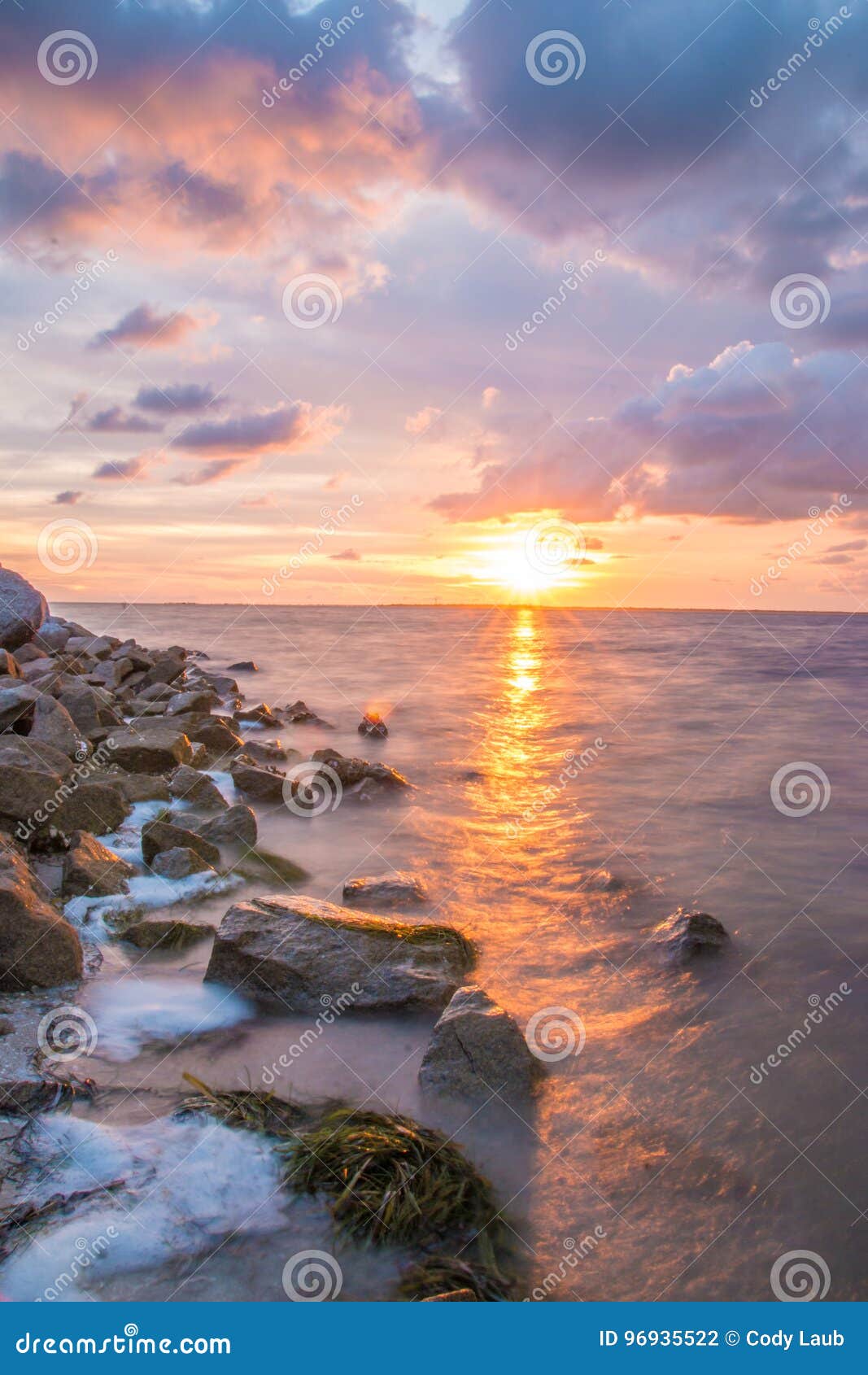 Rocky shore sunset stock photo. Image of orange, water - 96935522