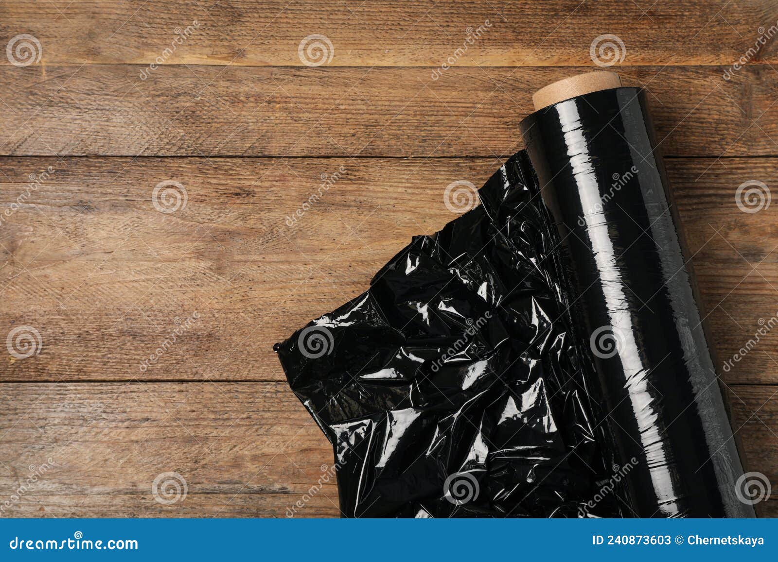 Roll of Plastic Stretch Wrap Film on Wooden Table, Top View. Space for ...