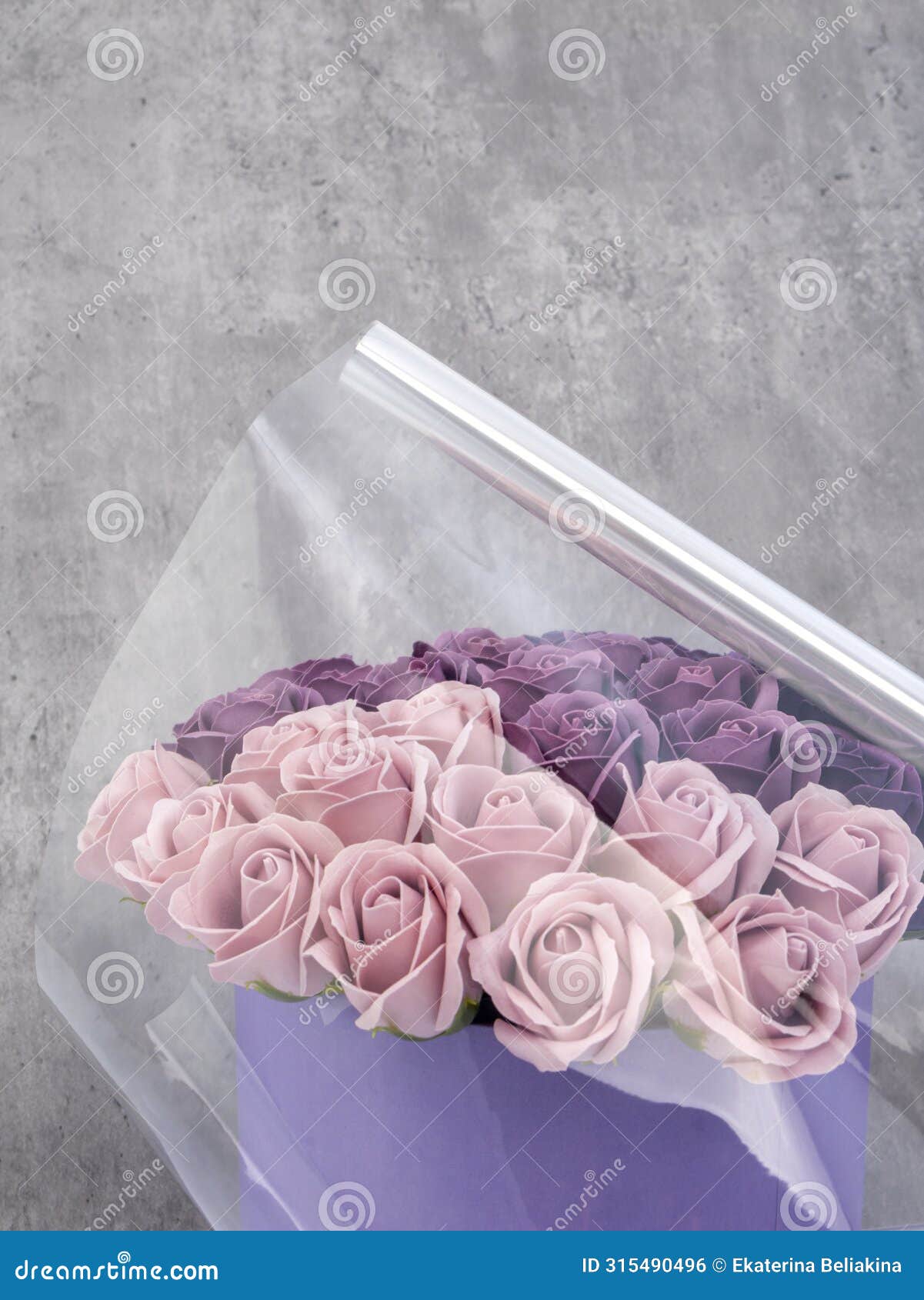 A Roll of Transparent Packaging Film and a Bouquet of Roses in a Box on ...