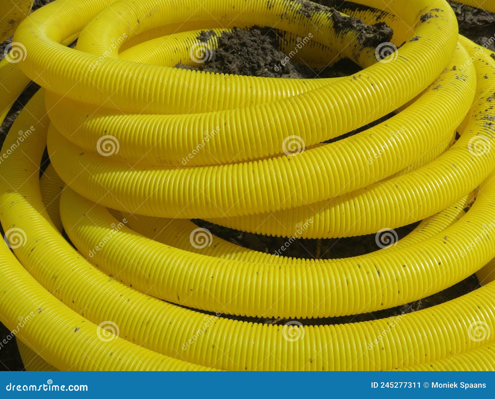 Roll of Yellow Plastic Pipe Laying on a Muddy Sidewalk Stock Image ...