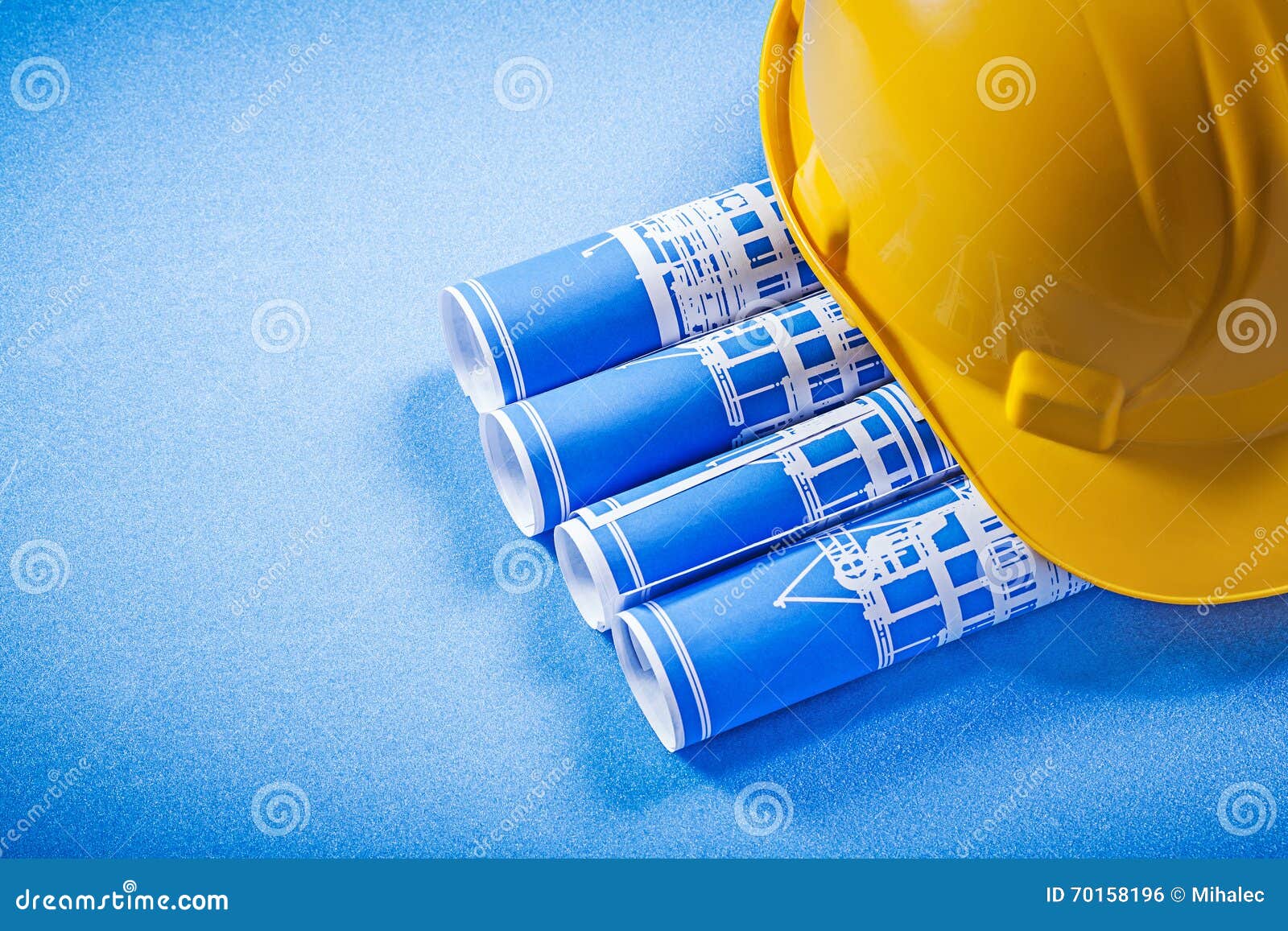 Rolled Up Construction Plans Hard Hat on Blue Background Stock Photo ...