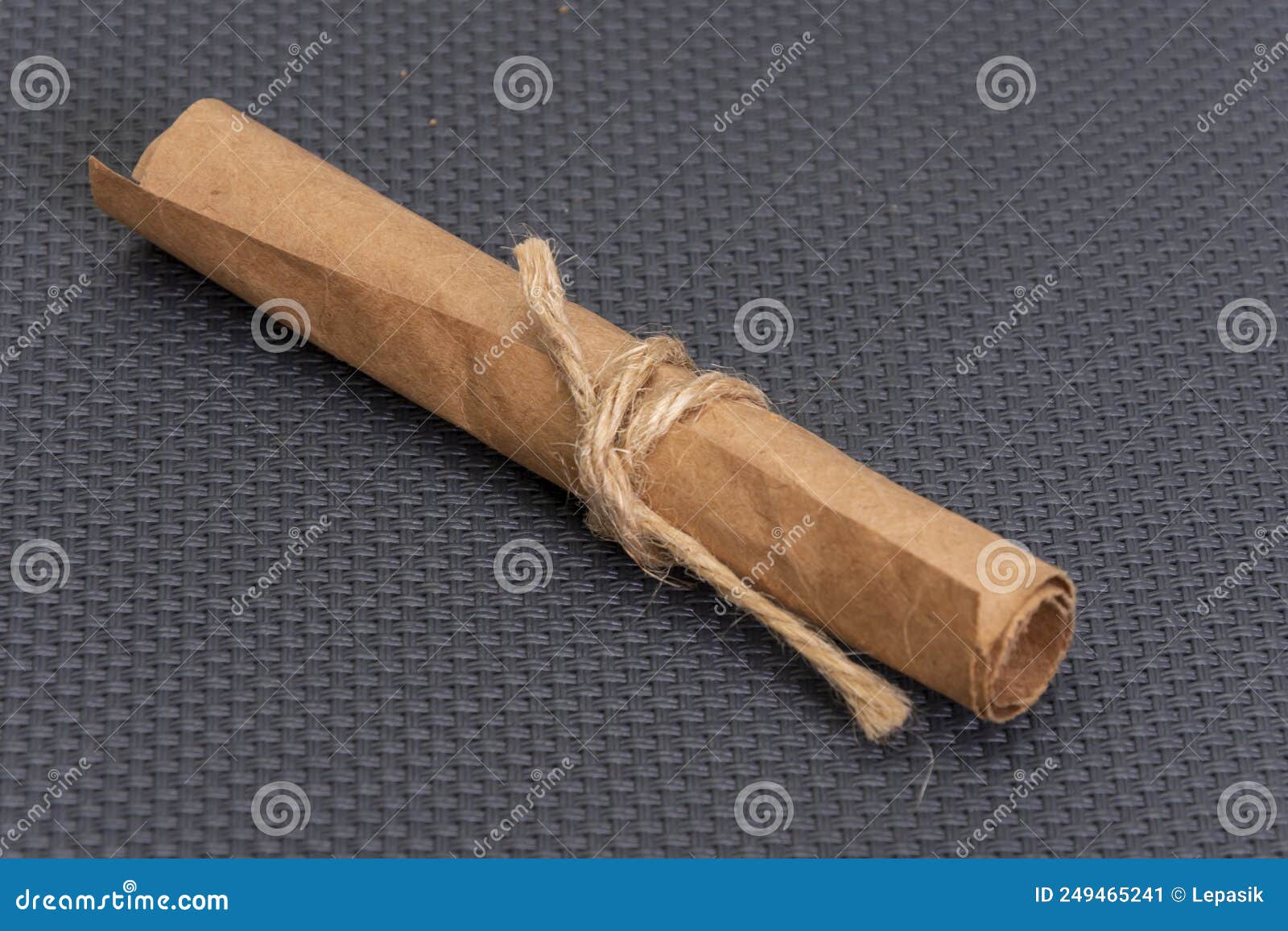 A Rolled-up Old Paper Note Tied with a Textured Rope on a Dark ...