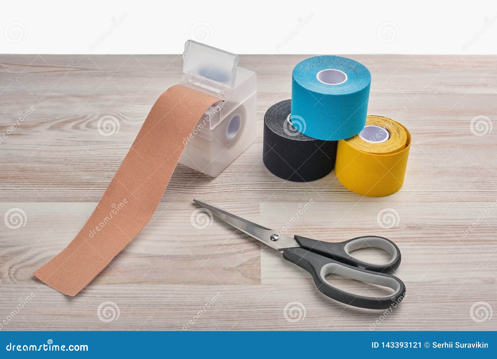 Rolls Of Colored Kinesio Tape With A Pair Of Scissors On A Wooden ...