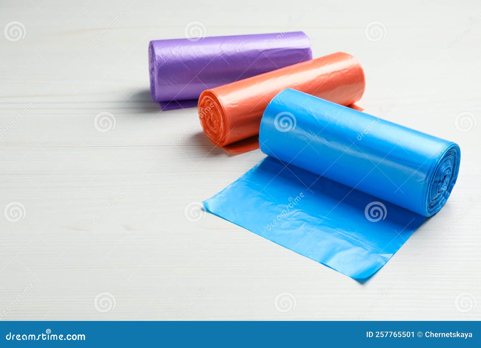 Rolls of Different Color Garbage Bags on White Wooden Table. Space for ...