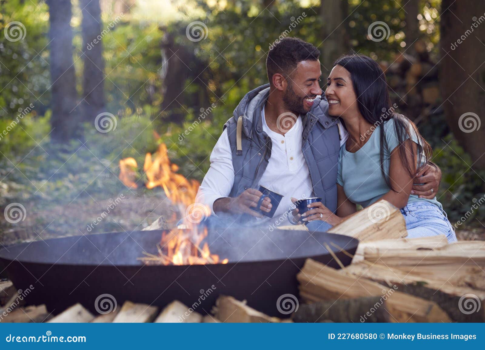 Romantic Couple Camping Sitting by Bonfire in Fire Bowl with Hot Drinks ...