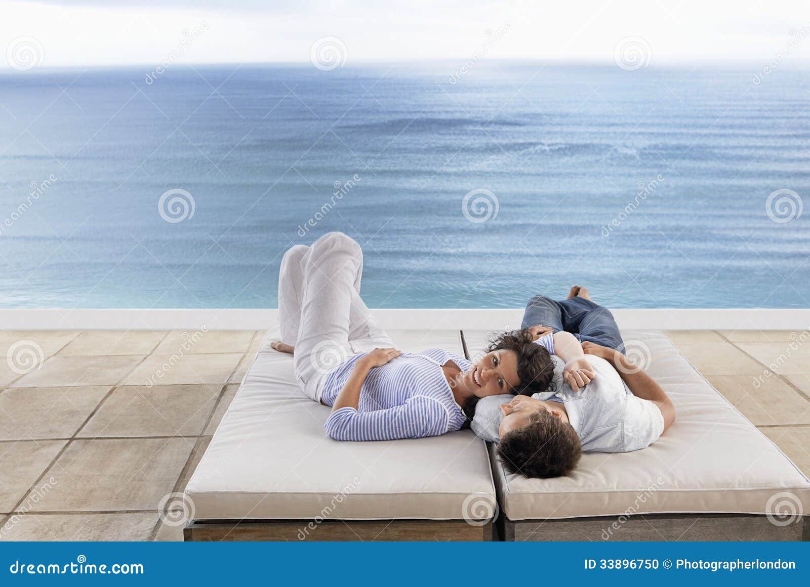 Romantic Couple Relaxing on Sunbeds by Infinity Pool Stock Photo ...