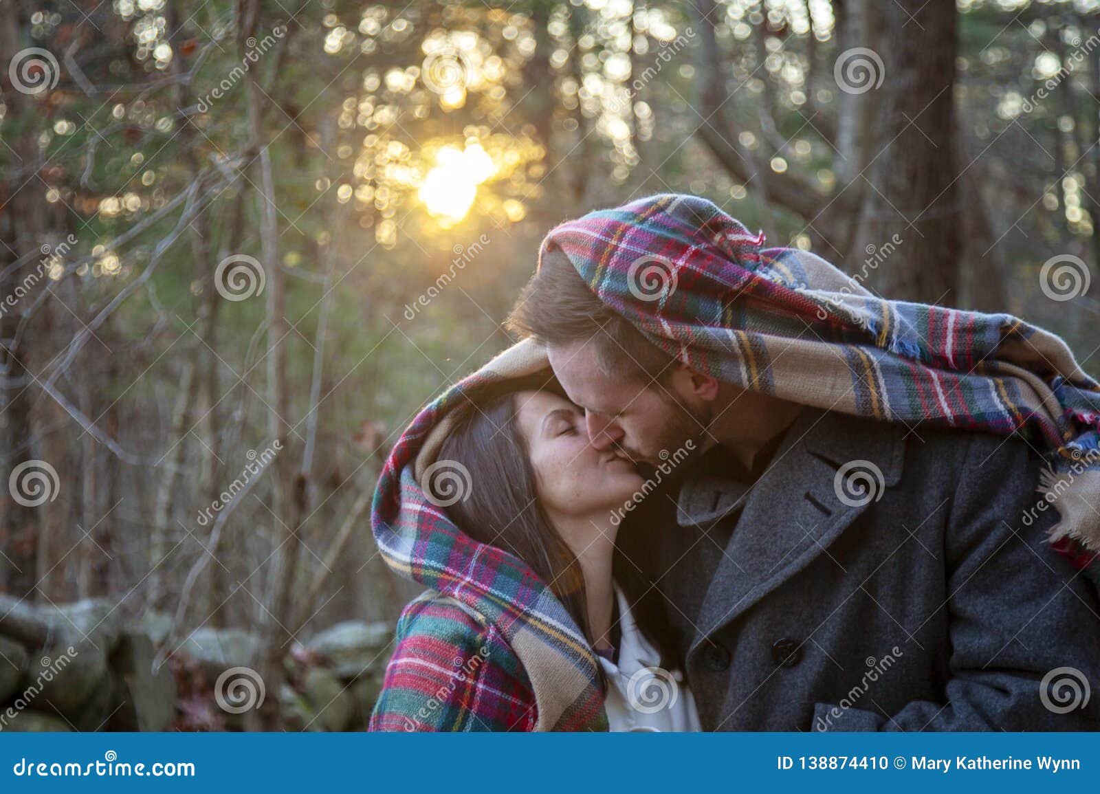 Romantic Young Couple Kissing Under A Blanket In The New England Woods