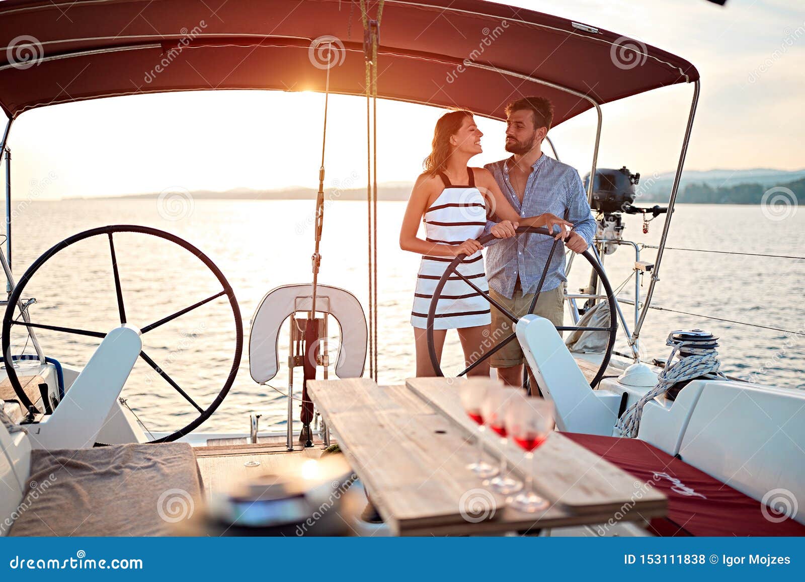 Romantic Couple Sailing On The Luxury Boat Together And Enjoy At Sunset