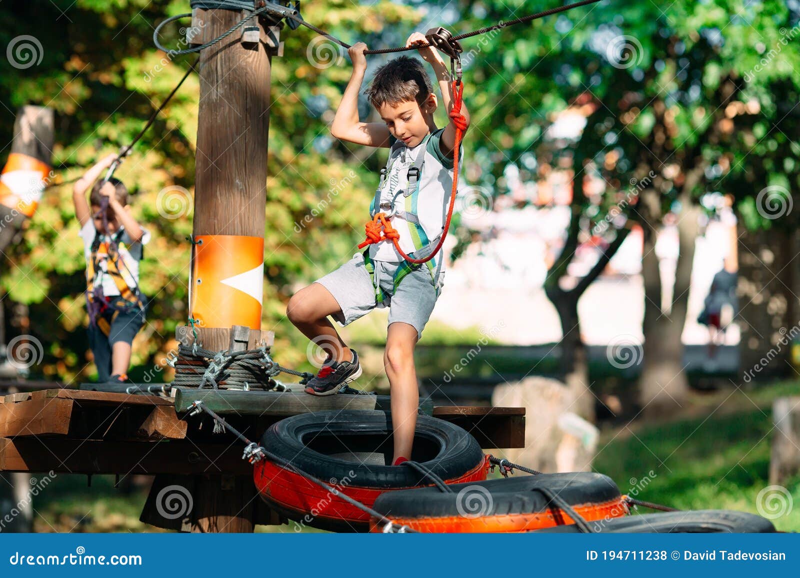 Rope Park. the Kid Passes the Obstacle in the Rope Park. Stock Photo ...