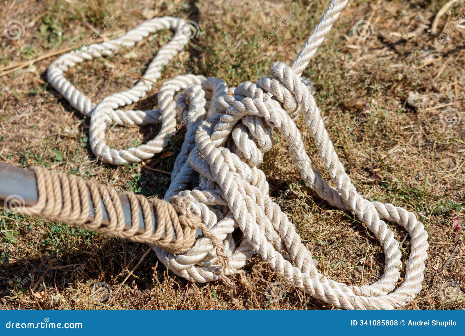 A Rope is Tied To a Pole and is Laying on the Ground Stock Photo ...