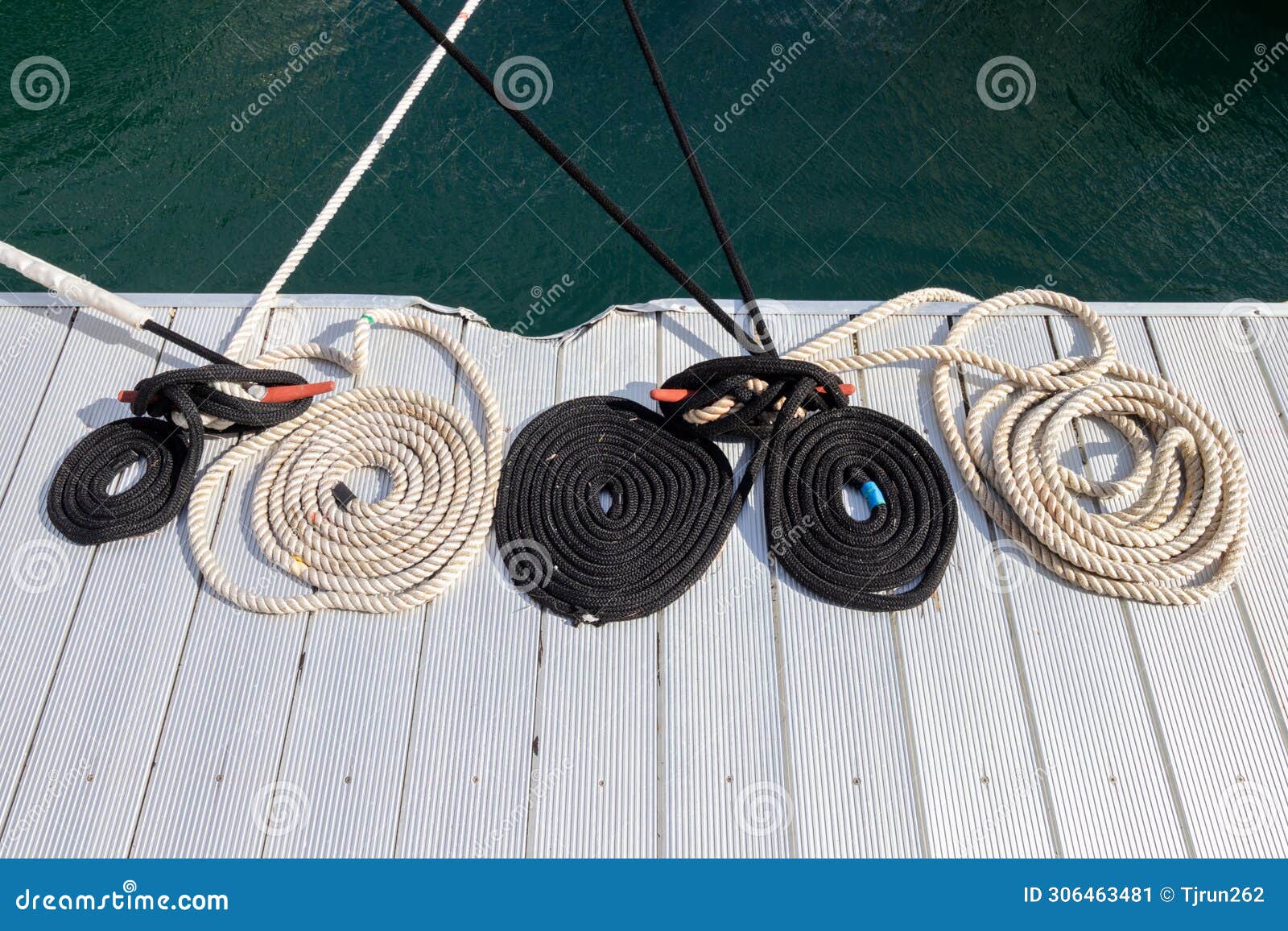 Ropes coiled on a dock stock image. Image of ropes, water - 306463481