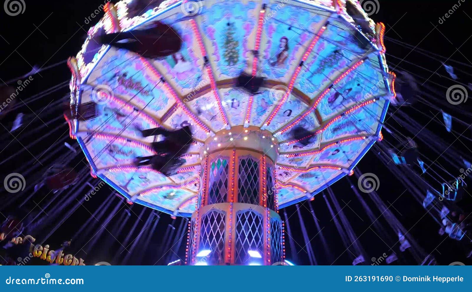 Rotating Lighted Chain Carousel Chairoplane at a Fun Fair at Night with ...