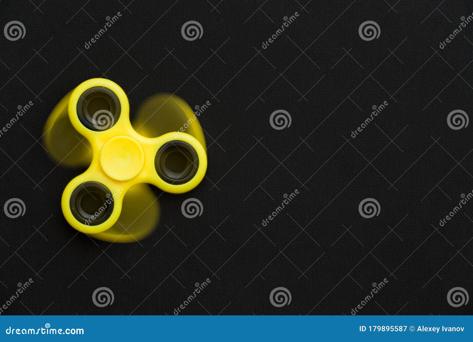 Rotating Yellow Fidget Spinner Device on Black Background.. Top View ...