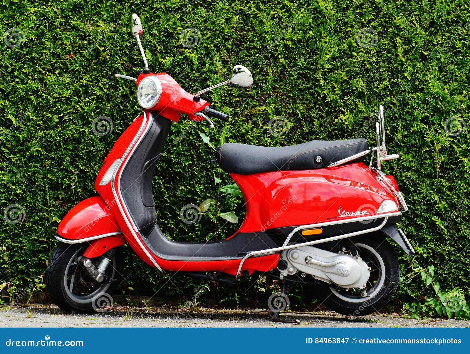 Roter Und Schwarzer Moped-Roller Neben Grünem Gras Bild. Bild: 84963847