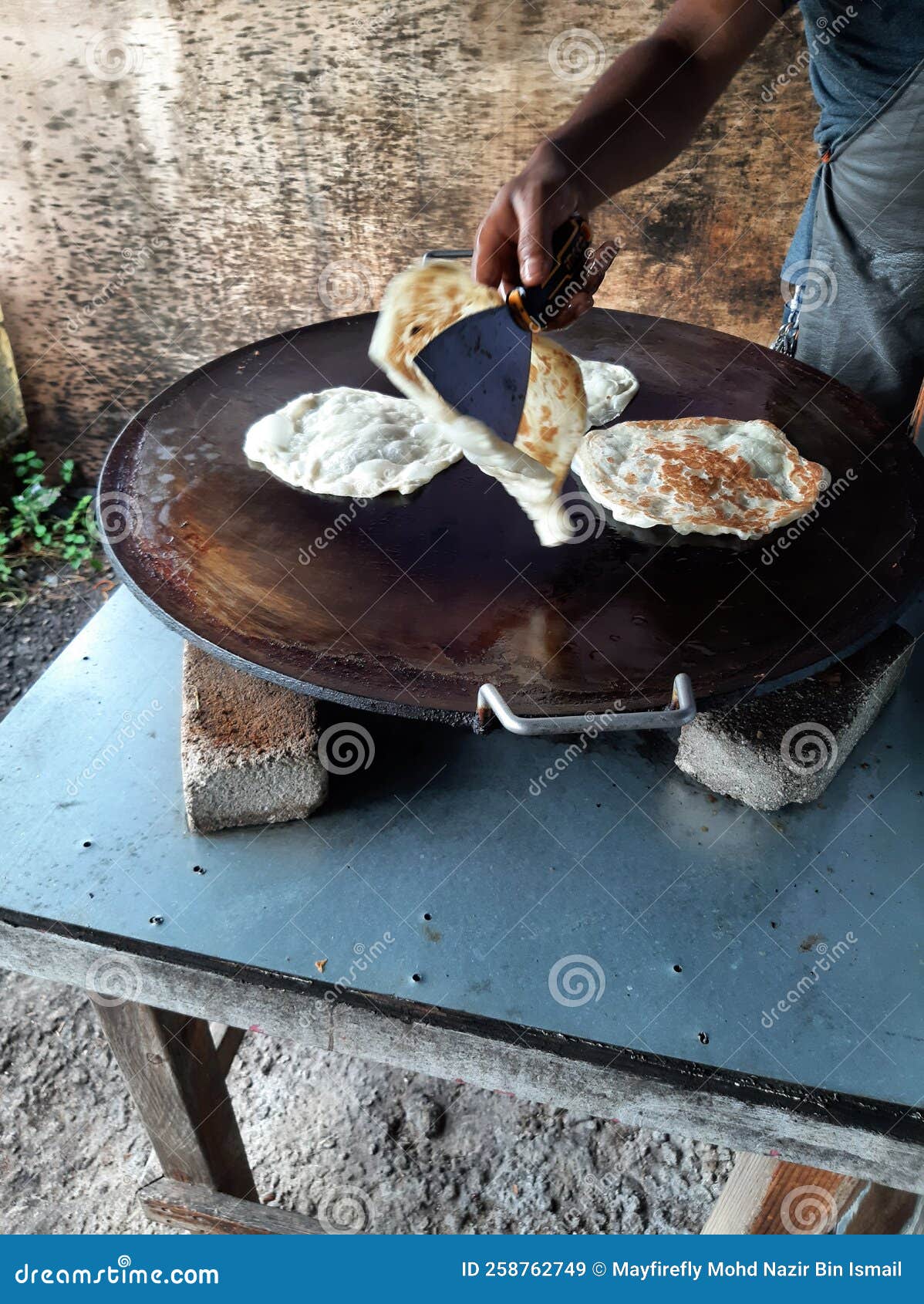 The Roti Canai Maker is Flipping the Roti Canai so that Both Sides are ...