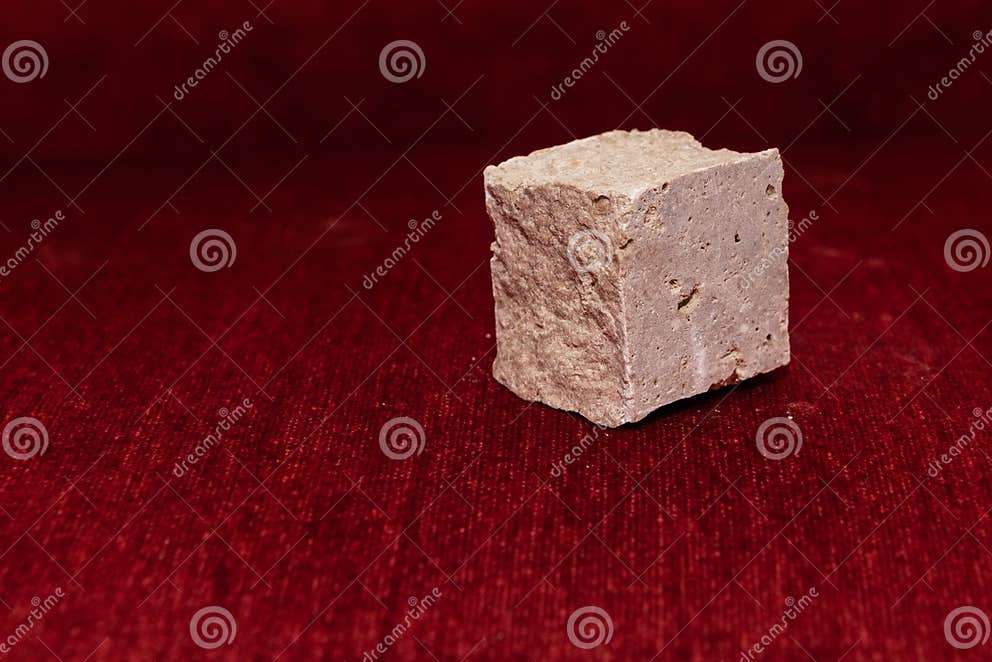 Rough Stone Cube Isolated on Blurred Red Background Stock Image - Image ...