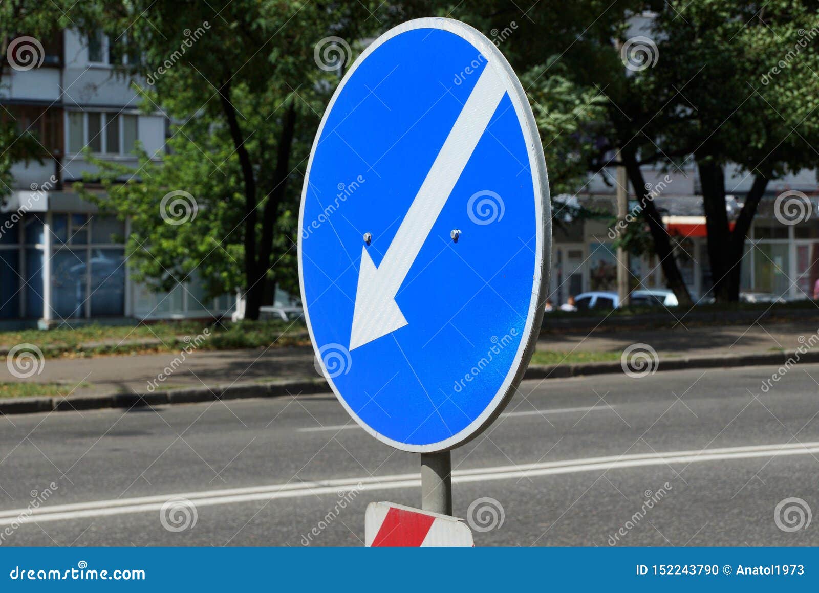Blue Road Sign with White Arrow on City Road Stock Photo - Image of ...