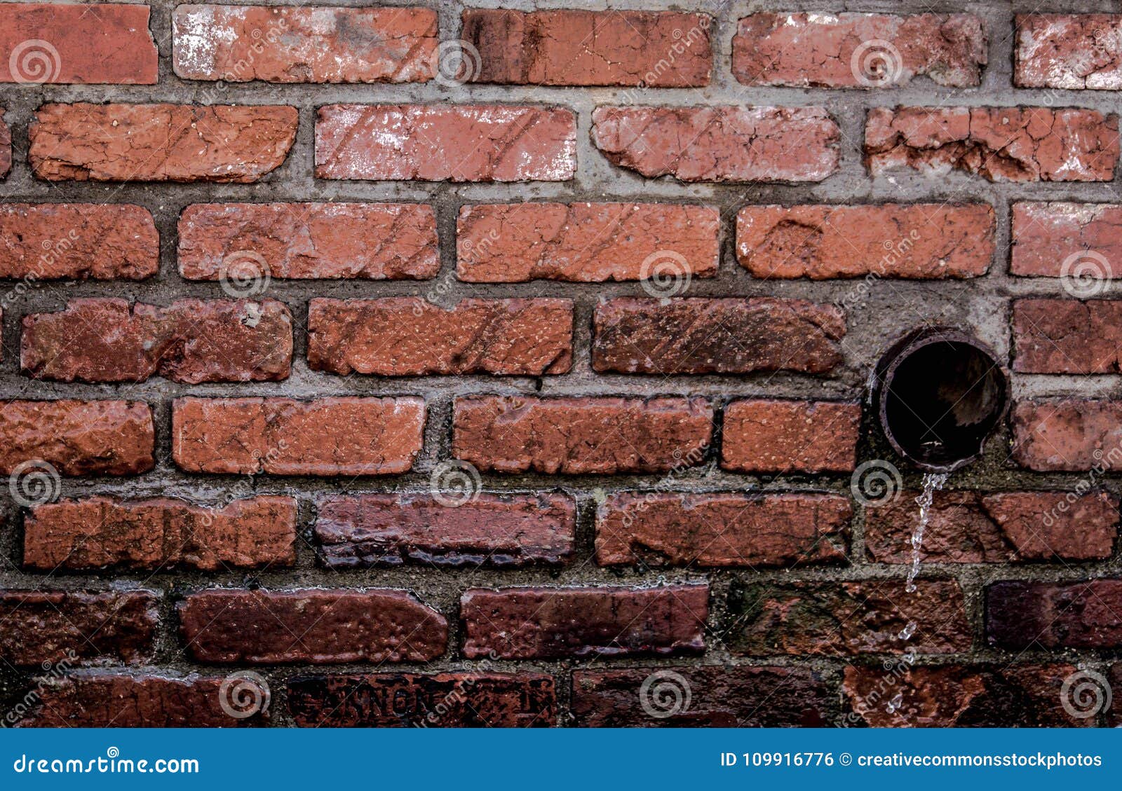 Round Brown Pipe Drainage With Liquid In Brown Bricked Concrete Wall ...