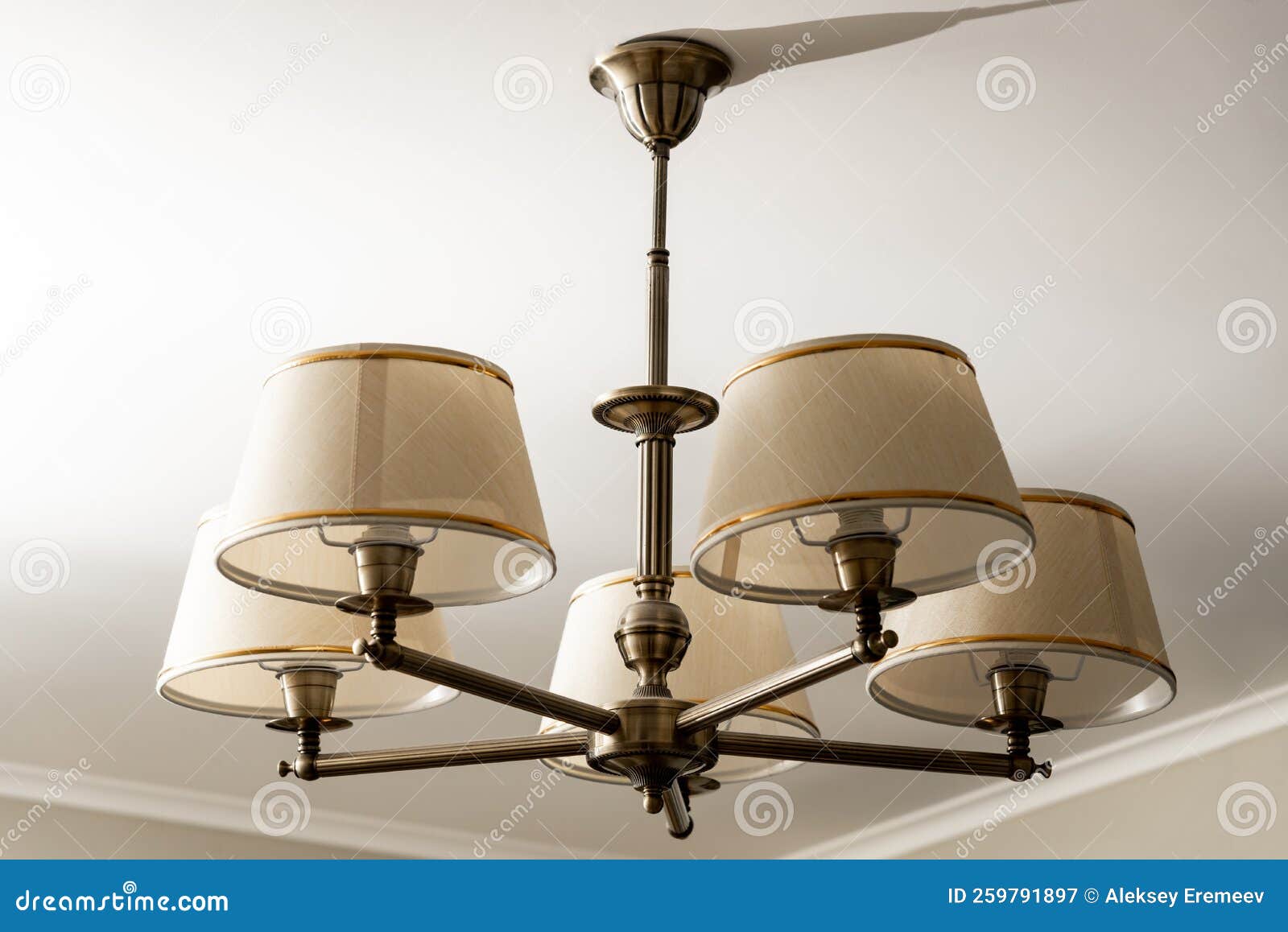 A Round Chandelier of Several Lamps Against a Light Ceiling, Full Frame ...