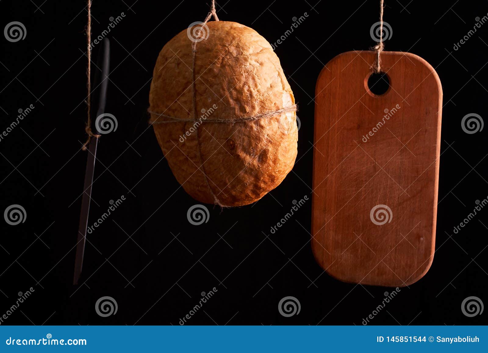 Round Fresh Bread Hanging on a Rope on a Black Background. Copy Space ...