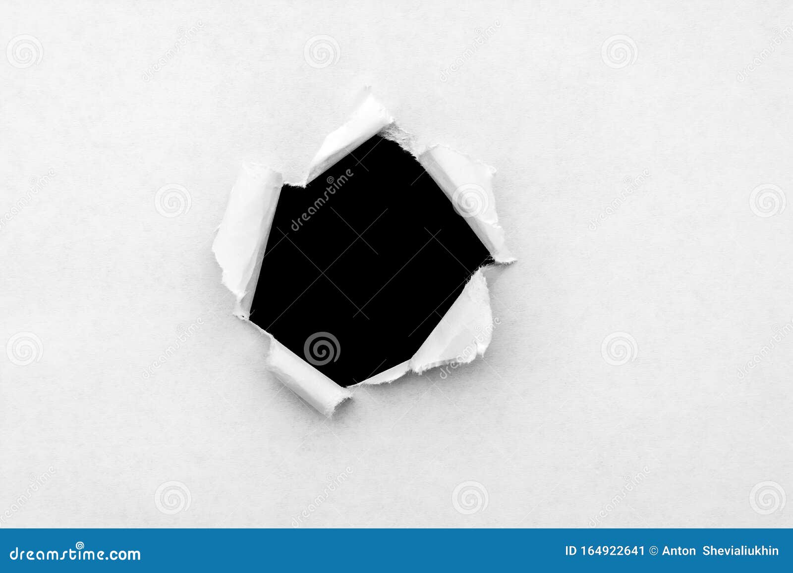 A Round Hole in White Paper with Torn Edges and a Black Isolated ...