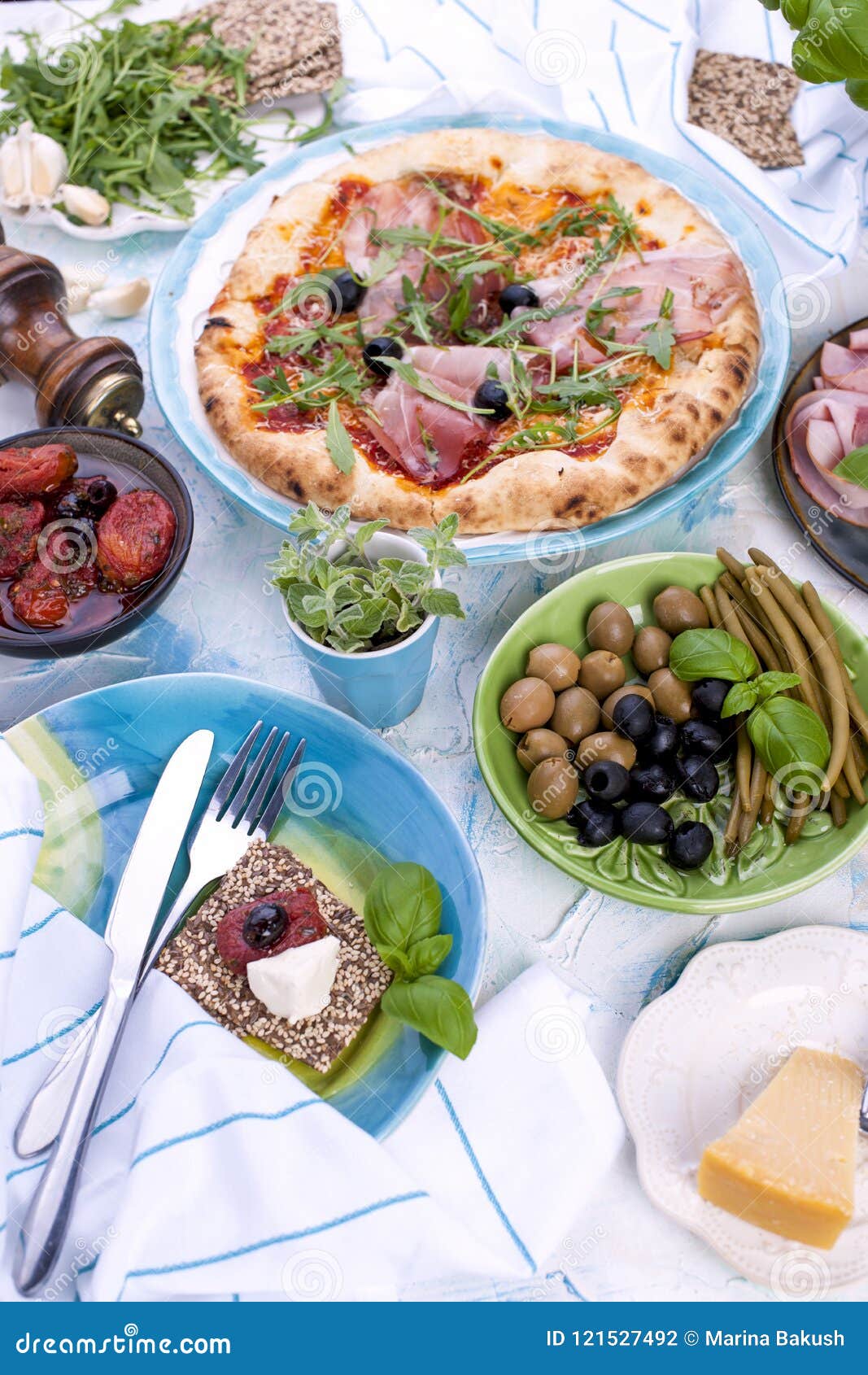 Round Large Pizza from the Oven with Prosciutto and Olives, Arugula and ...