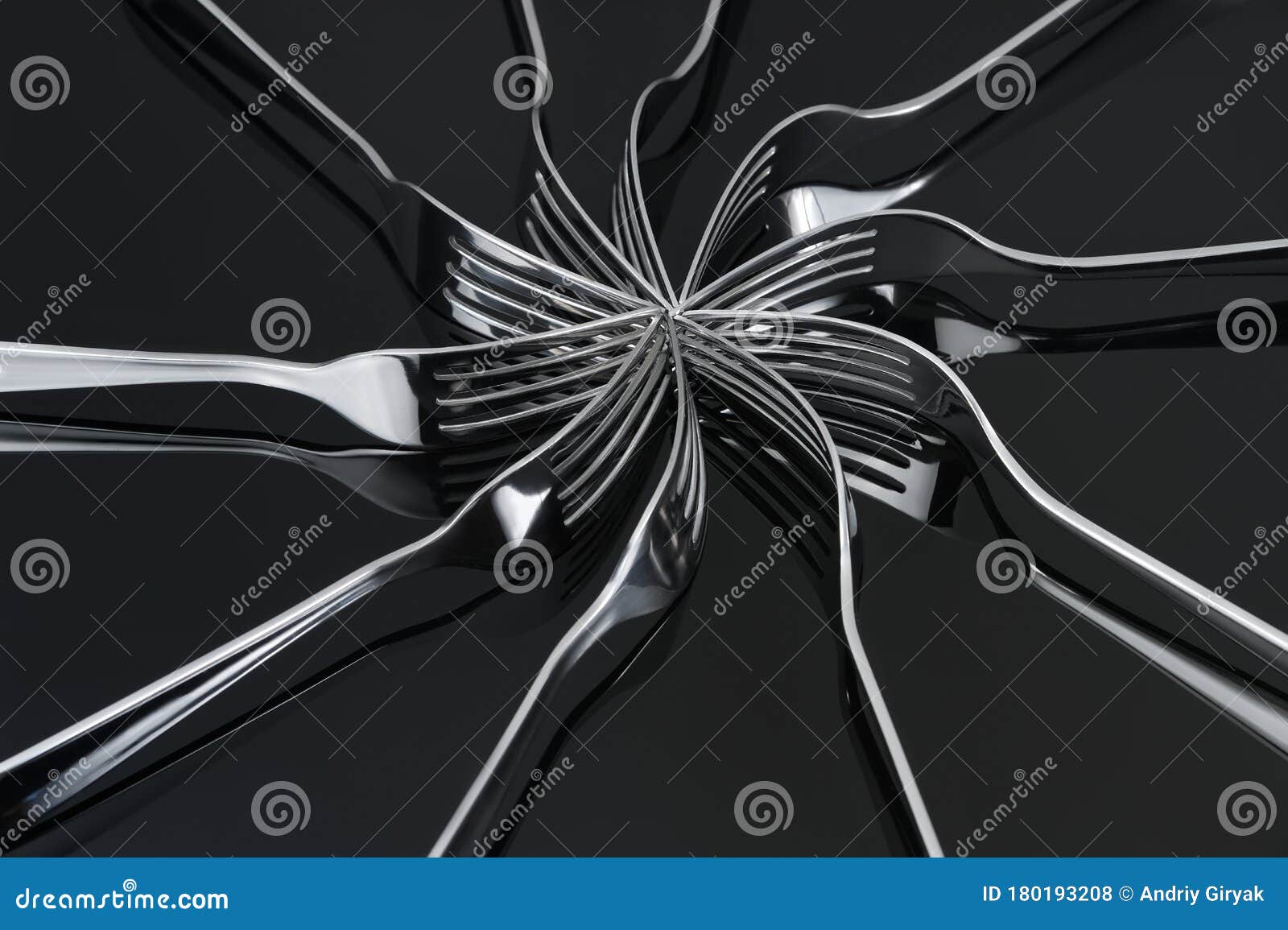 Round Pattern with Many Silver Forks on Black Mirror Background ...