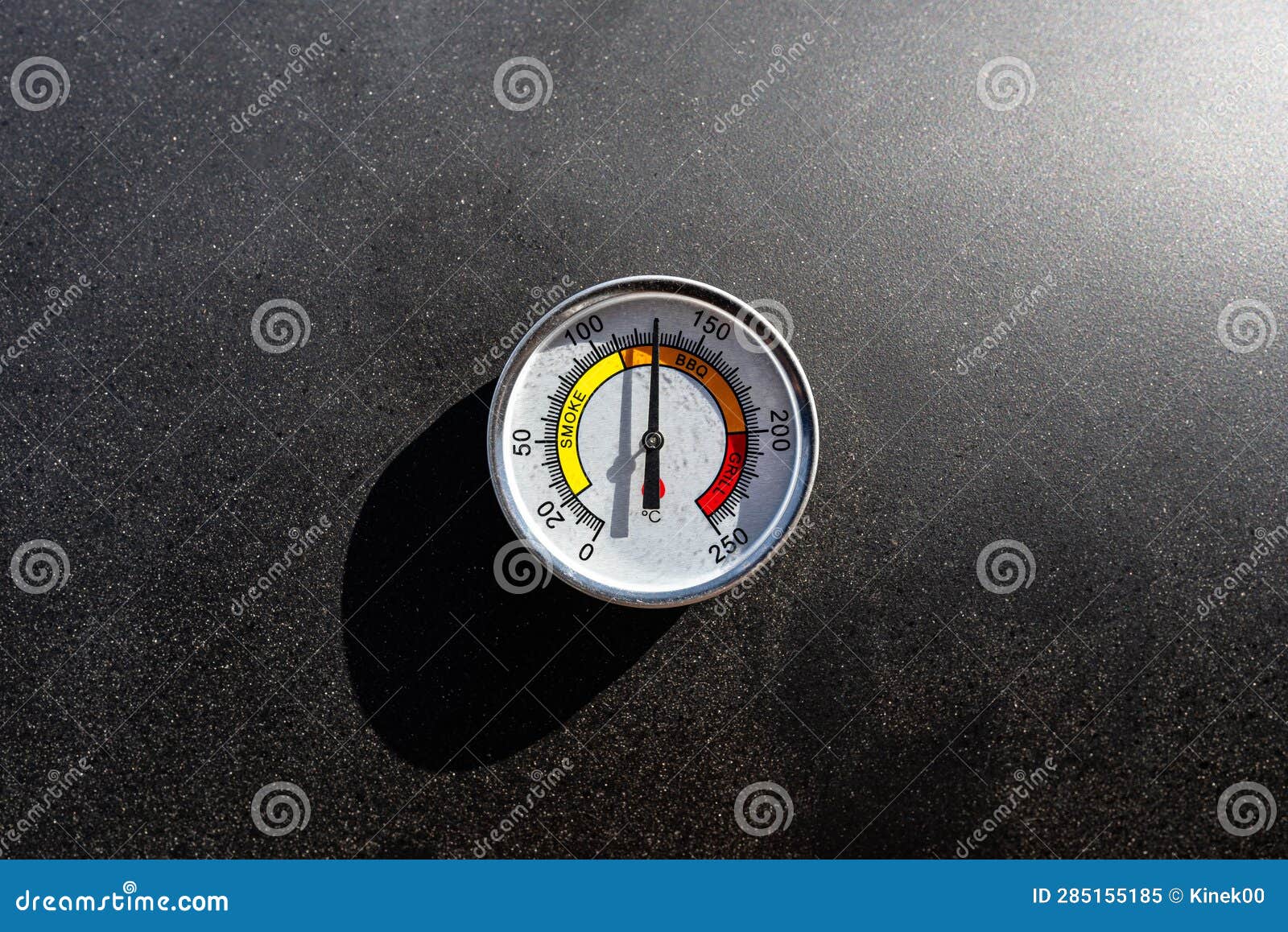 A Round Thermometer Showing 130 Degrees Celsius Placed on a Charcoal ...