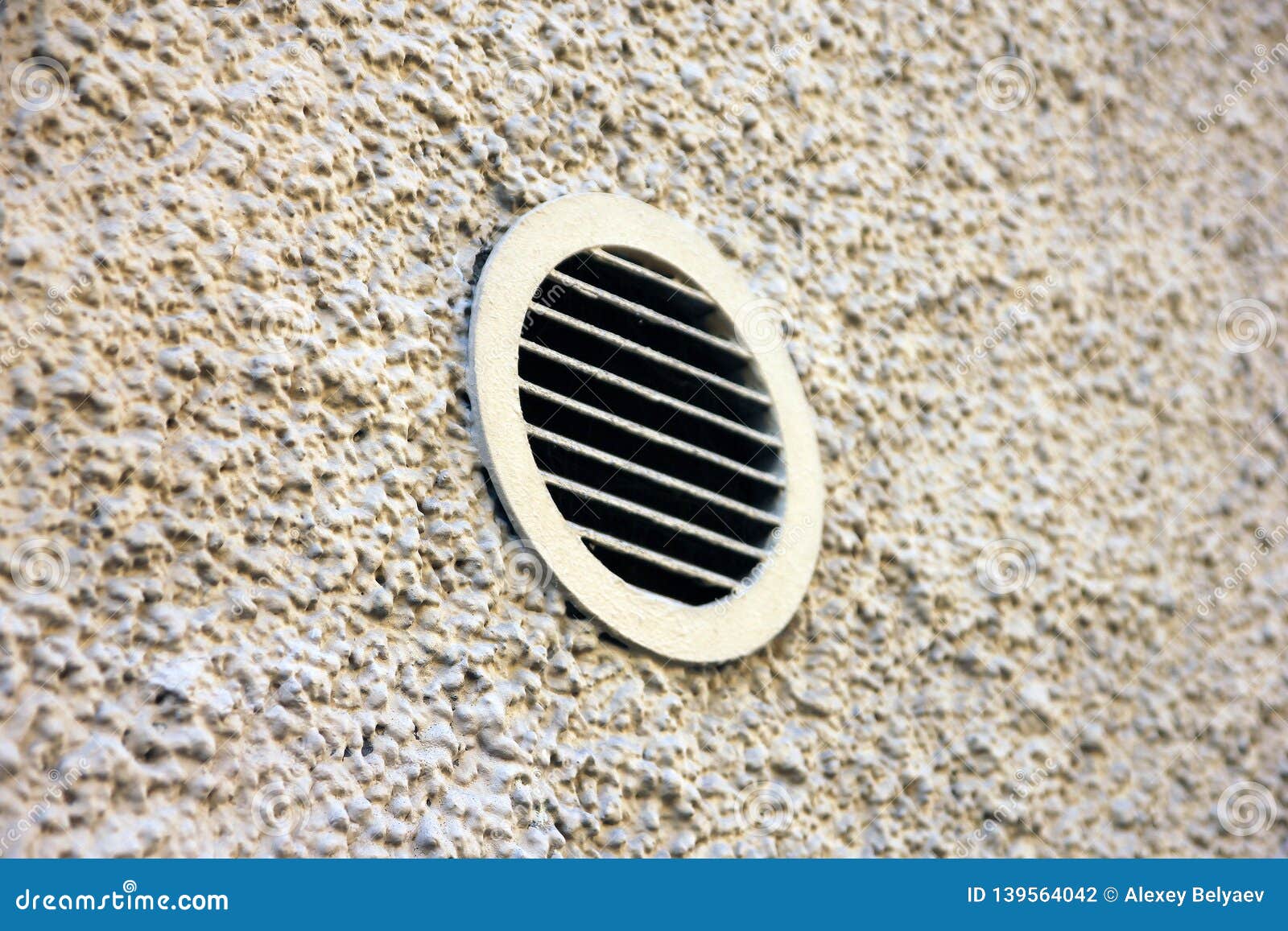 Round Ventilation Grille on Rough Yellow Plaster Wall of Building ...