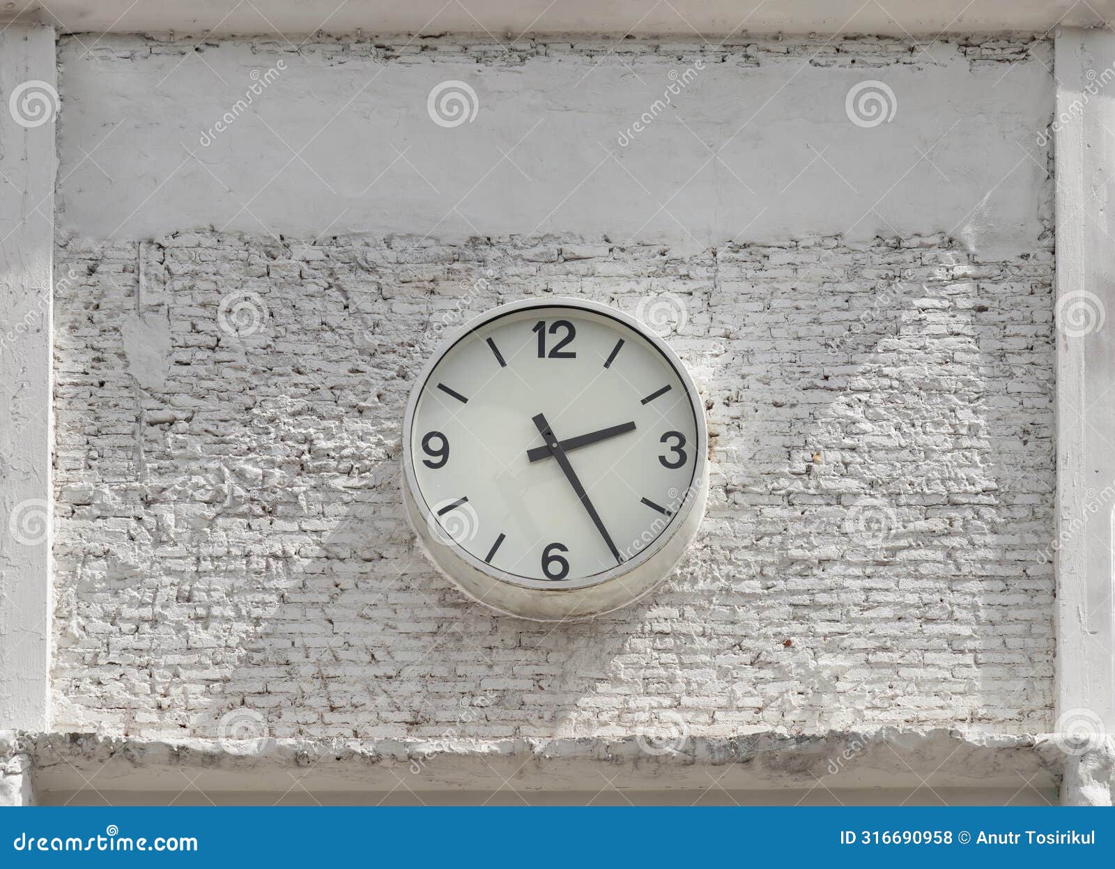 Round White Watch Face with Numbers Hanging on White Brick Wall. Stock ...