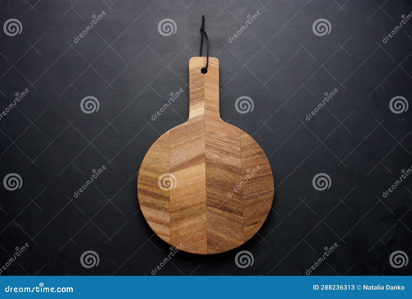 Round Wooden Kitchen Cutting Board with Handle on a Black Background ...
