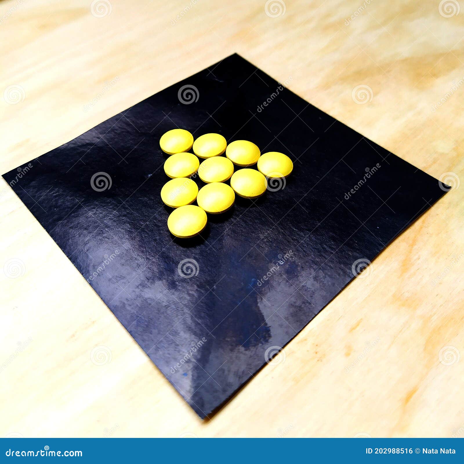 Round Yellow Tablets in the Form of a Triangle on a Black Square Stock ...