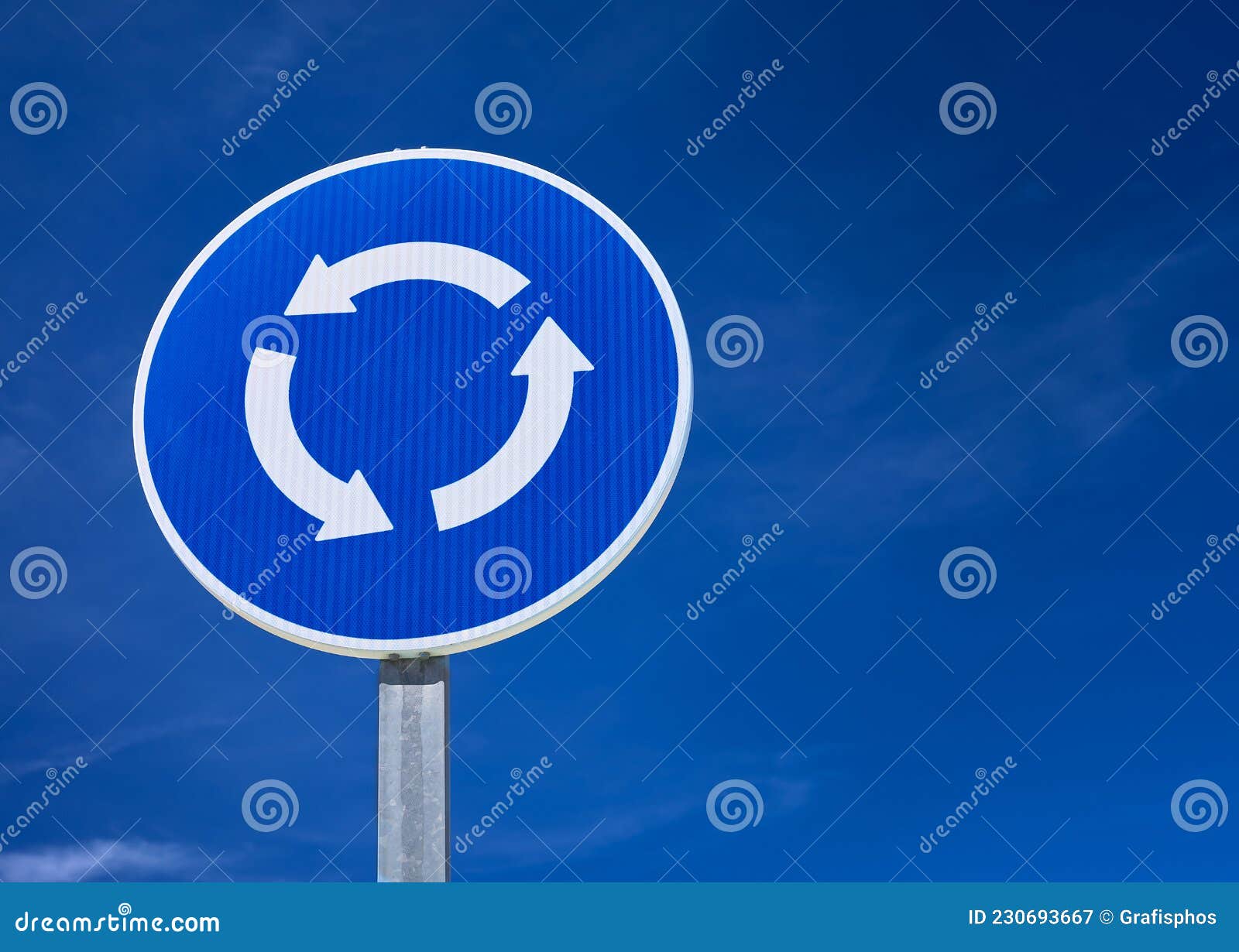 Roundabout Sign on a Blue Sky Stock Image - Image of arrow, asphalt ...