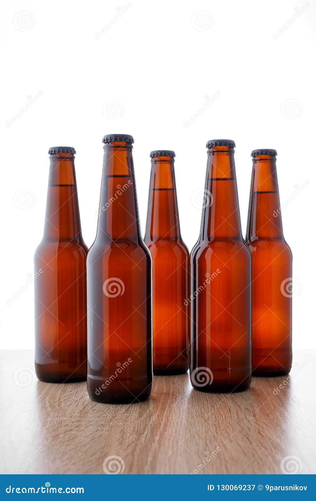 A Row of Beer Bottles on Table, White Background. Stock Image - Image ...