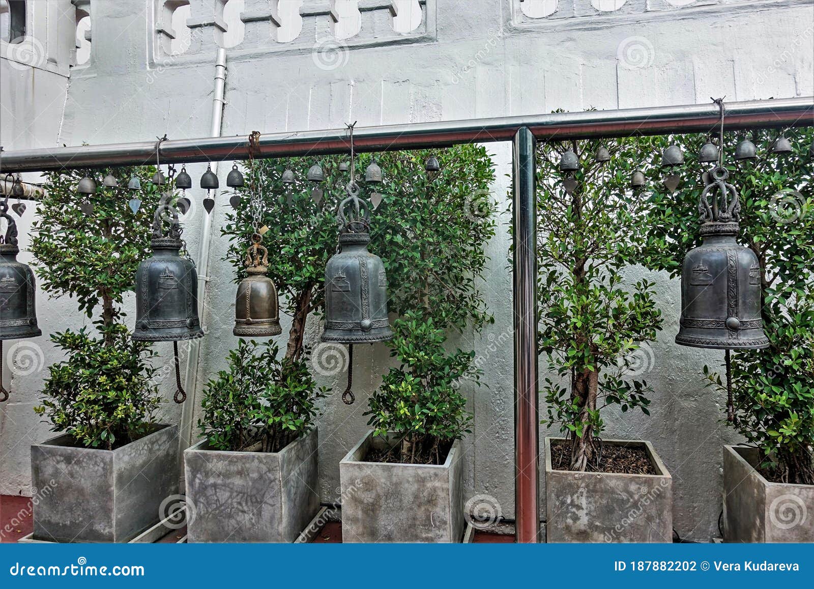 A Row of Bells on the Background of a White Wall of the Temple. Stock ...