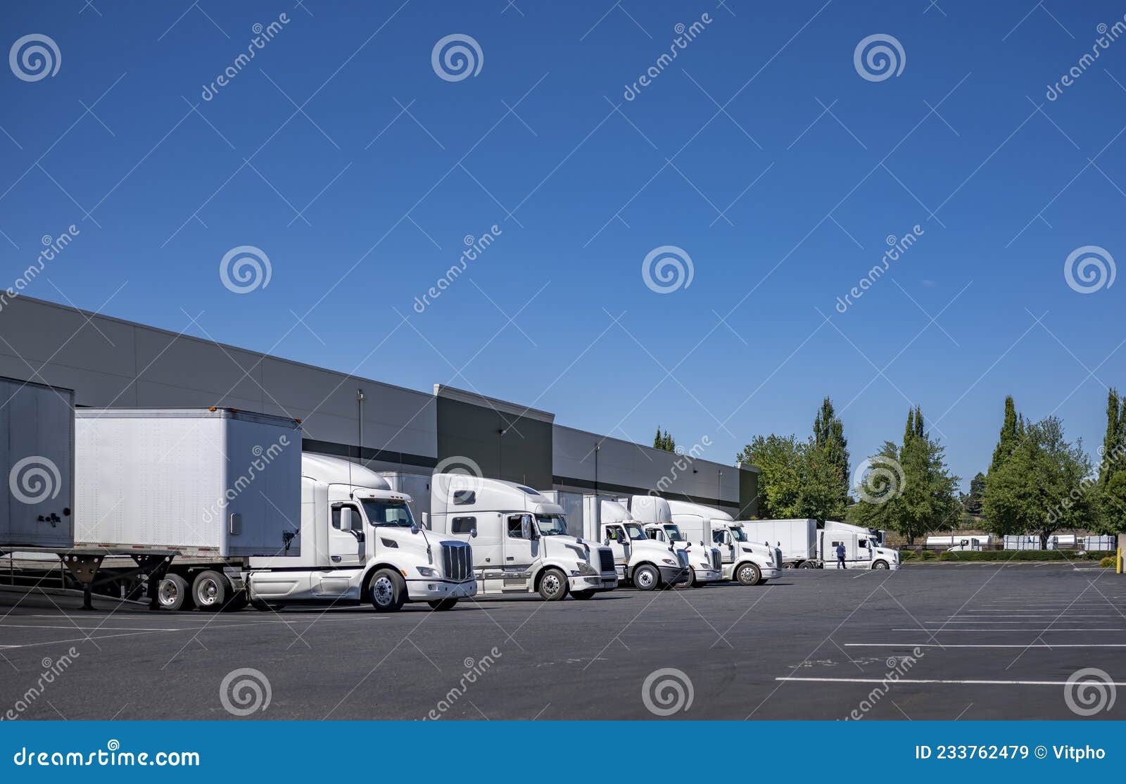 Row of the Big Rig Semi Trucks with Semi Trailers Standing at Warehouse ...
