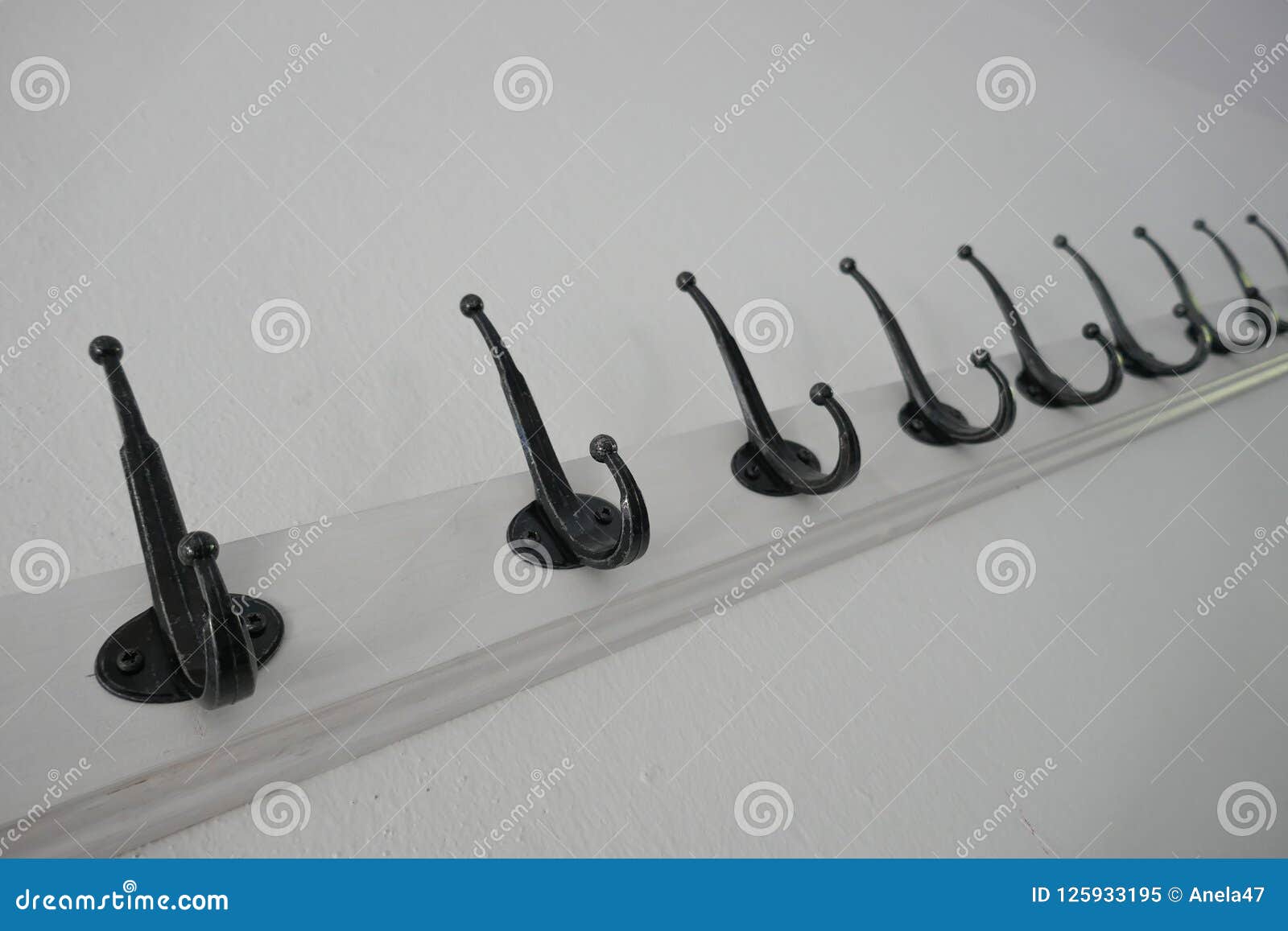 A Row of Black Hooks on a White Wooden Ledge on the Wall Stock Image ...