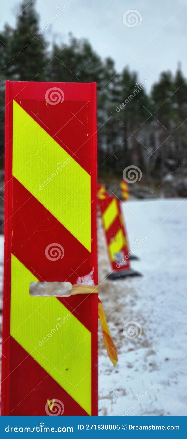 Row of Bright Red and Yellow Signs on the Side of a Snow Covered Forest ...