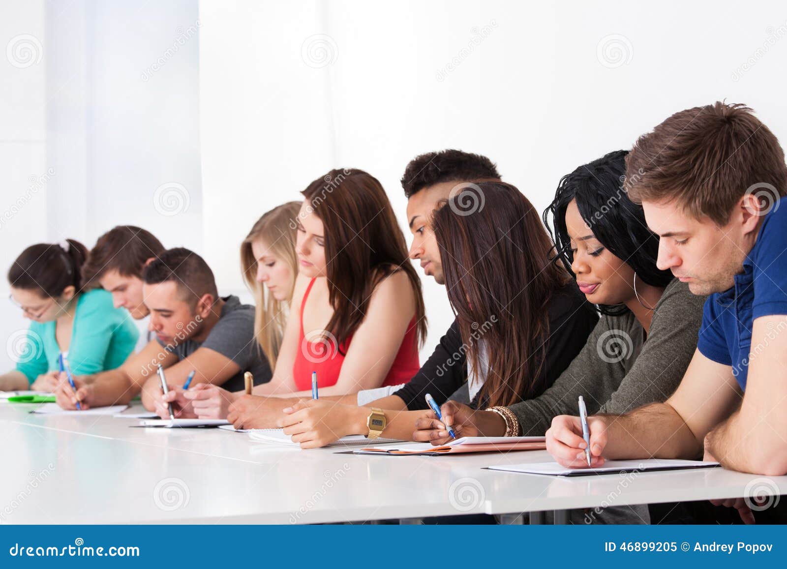 Row of College Students Writing at Desk Stock Image - Image of person ...