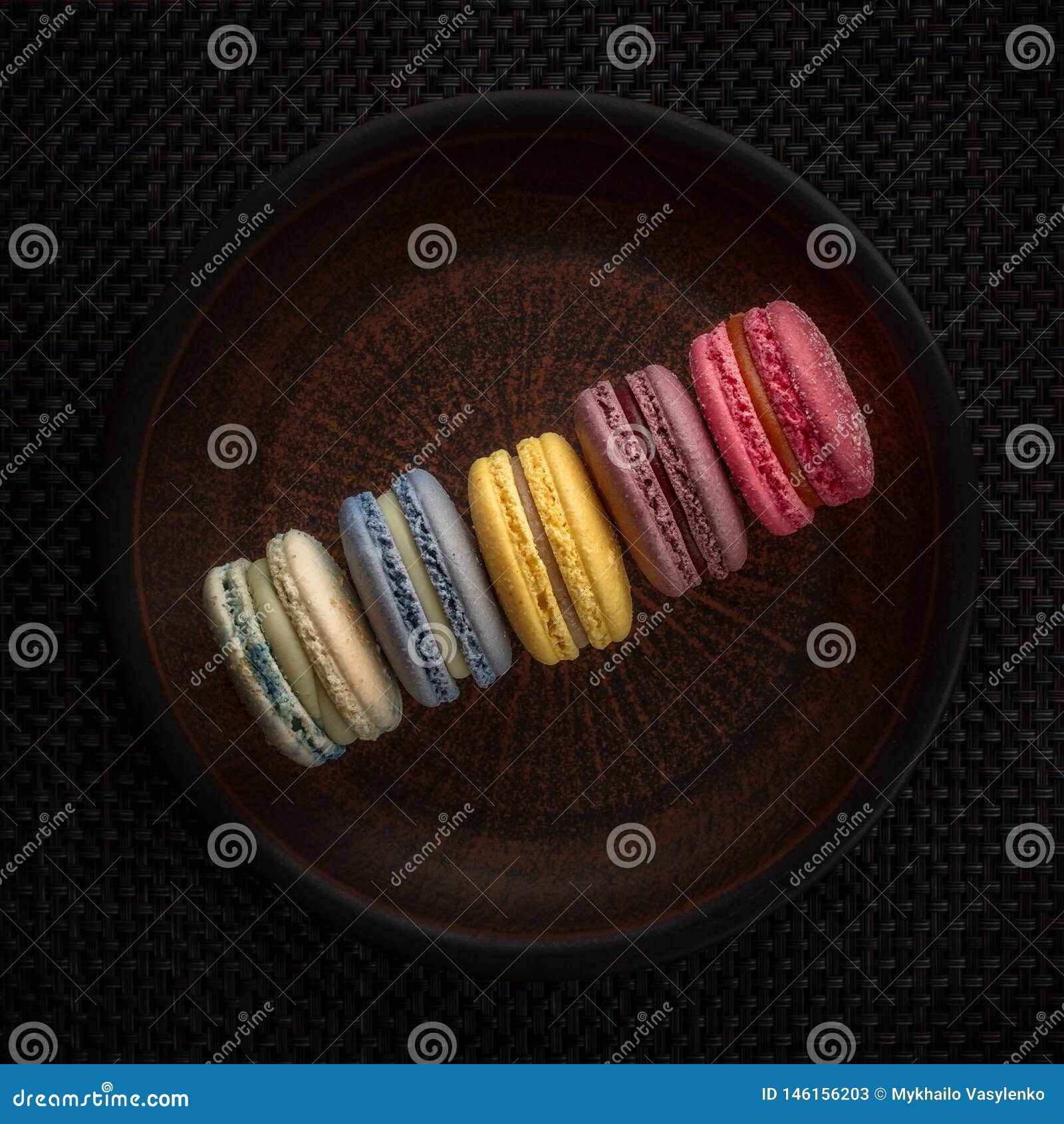 Five Colored Macarons on the Brown Plate and Pattern Background Stock ...