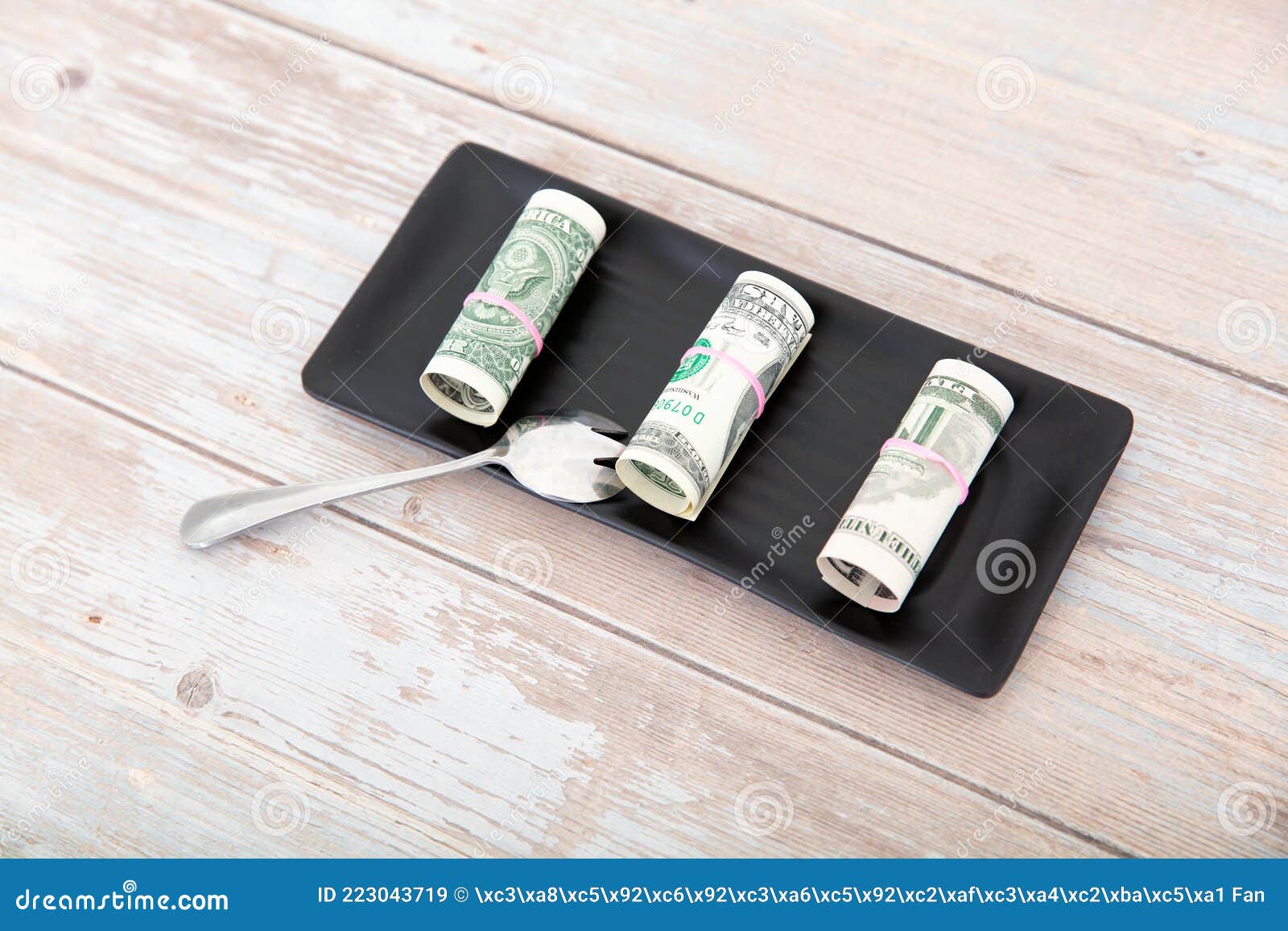 A Row of Neatly Rolled Dollar Bills on a Plate on the Dining Table ...