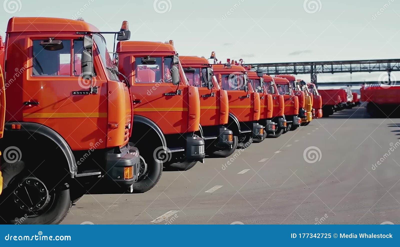Row of New Trucks Standing on a Concrete Surface on Blue Sky Background ...