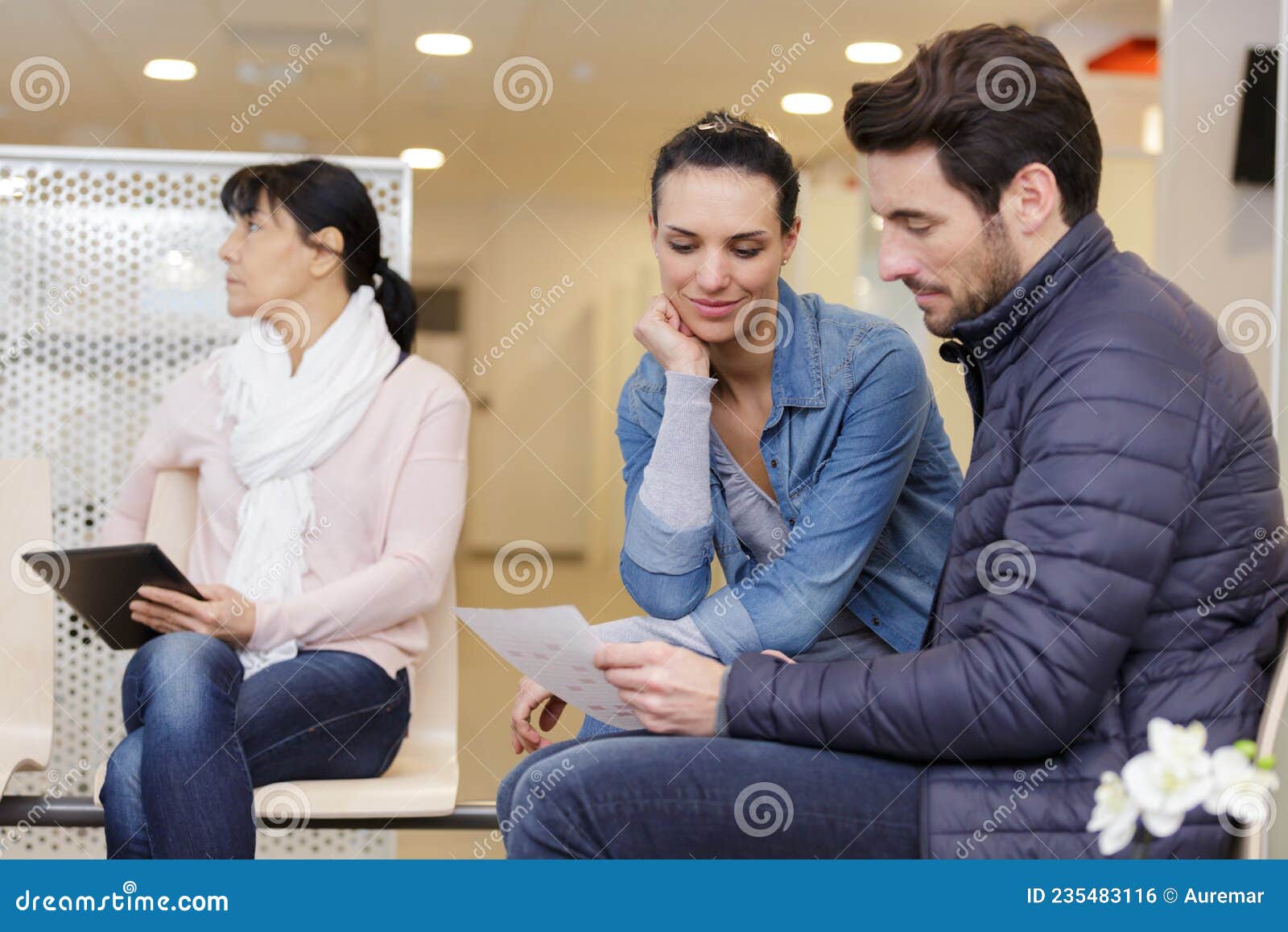 Row People Sitting Side by Side while Waiting Stock Photo - Image of ...