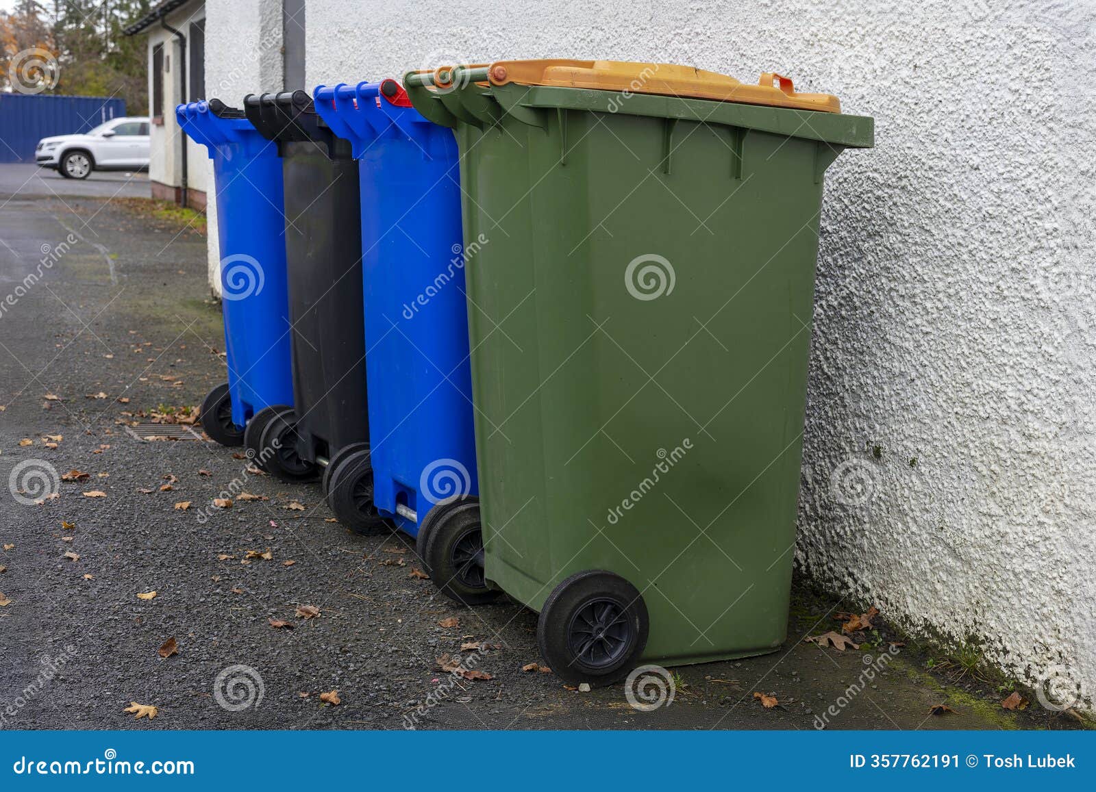 Row of Recycling Wheelie Bins with Wheels beside White Wall Stock Image ...