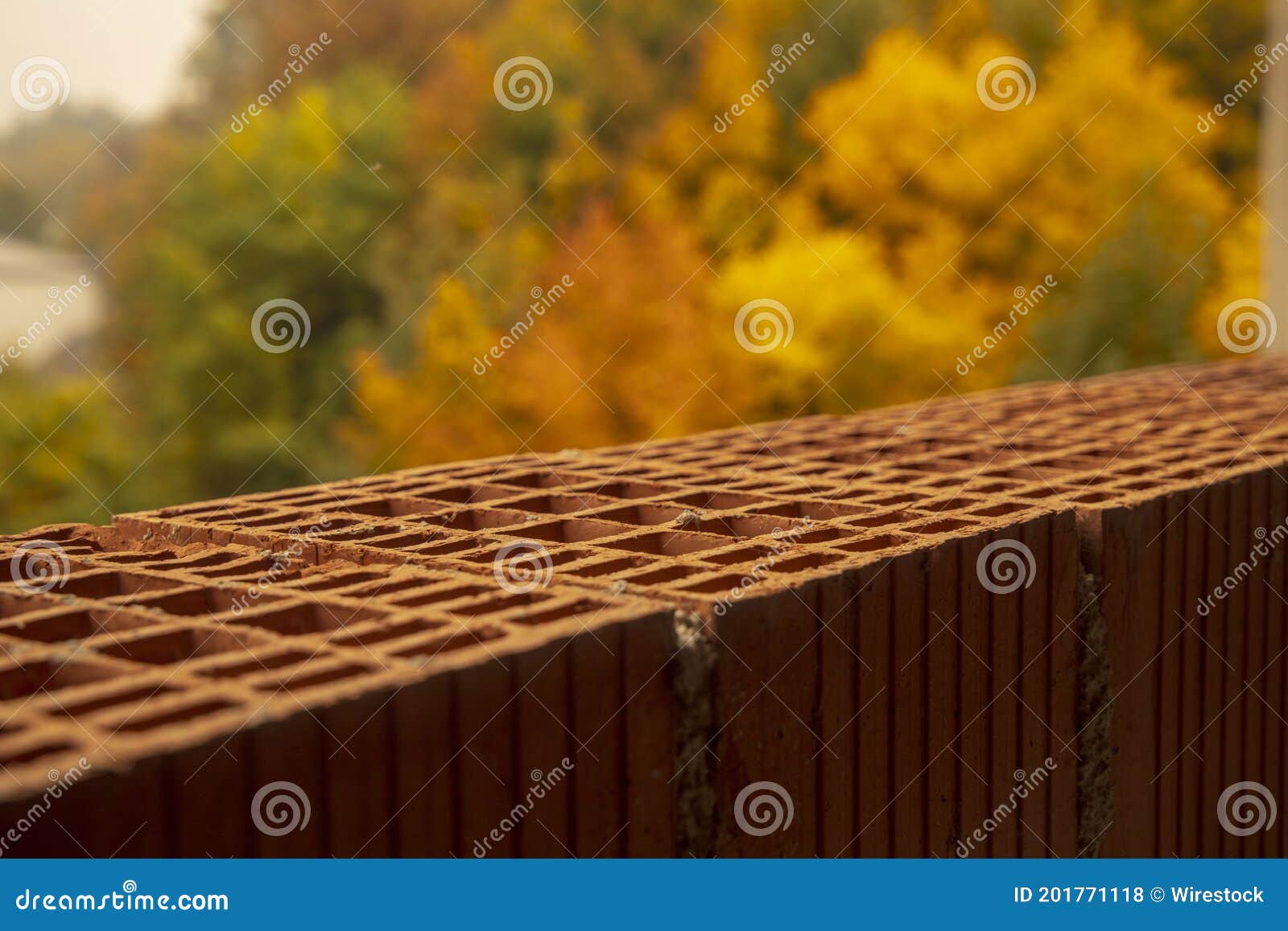 Row of Red Bricks with Autumn Trees in the Background Stock Photo ...