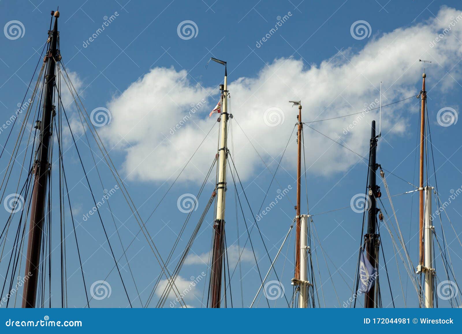 Row of Sail Boat Mast Tips and Attached Cables Against a Cloudy Blue ...