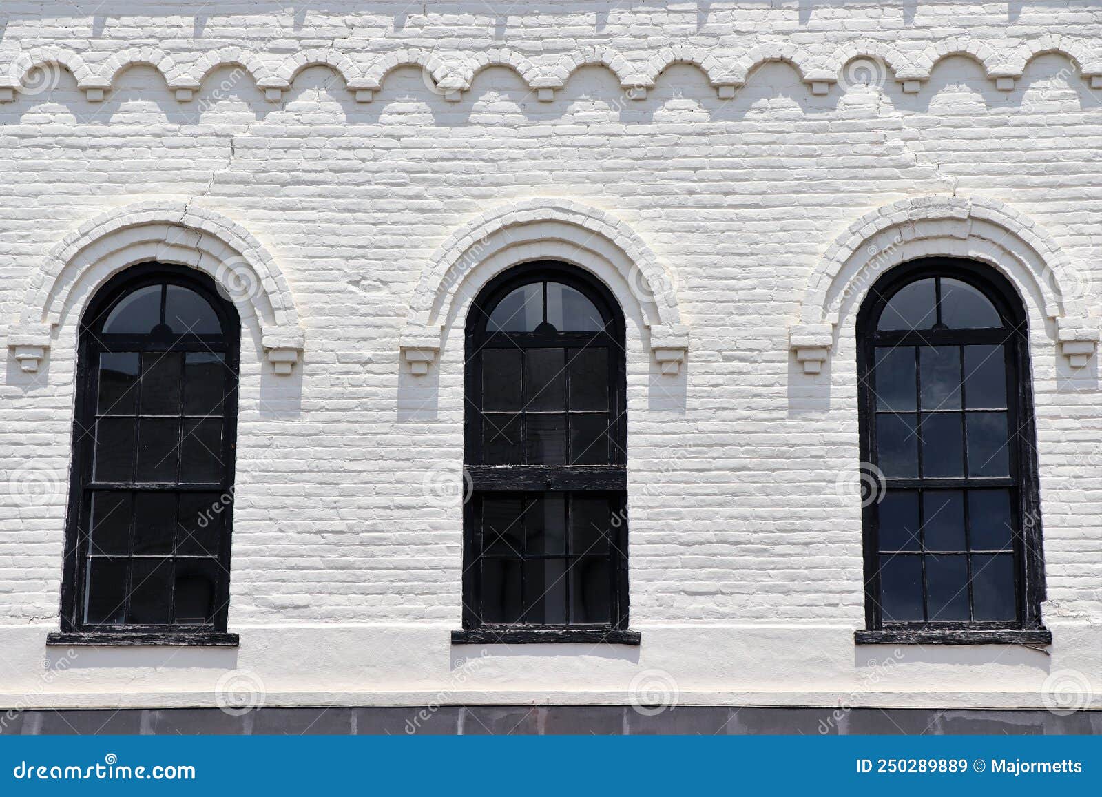 Row of Three Arched Windows in White Brick Building Stock Image - Image ...